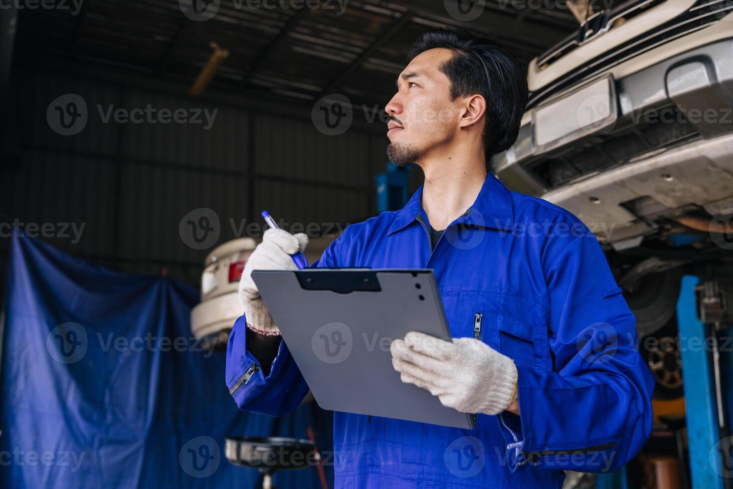 Asian Japanese Mechanic Male Worker Employee Checking Car In Auto
