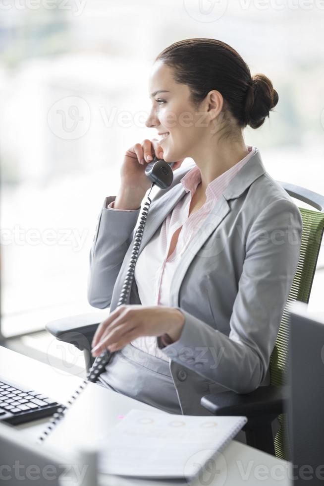 Smiling young businesswoman talking on landline phone in office 754796 ... Smiling young businesswoman talking on landline phone in office 754796 ...