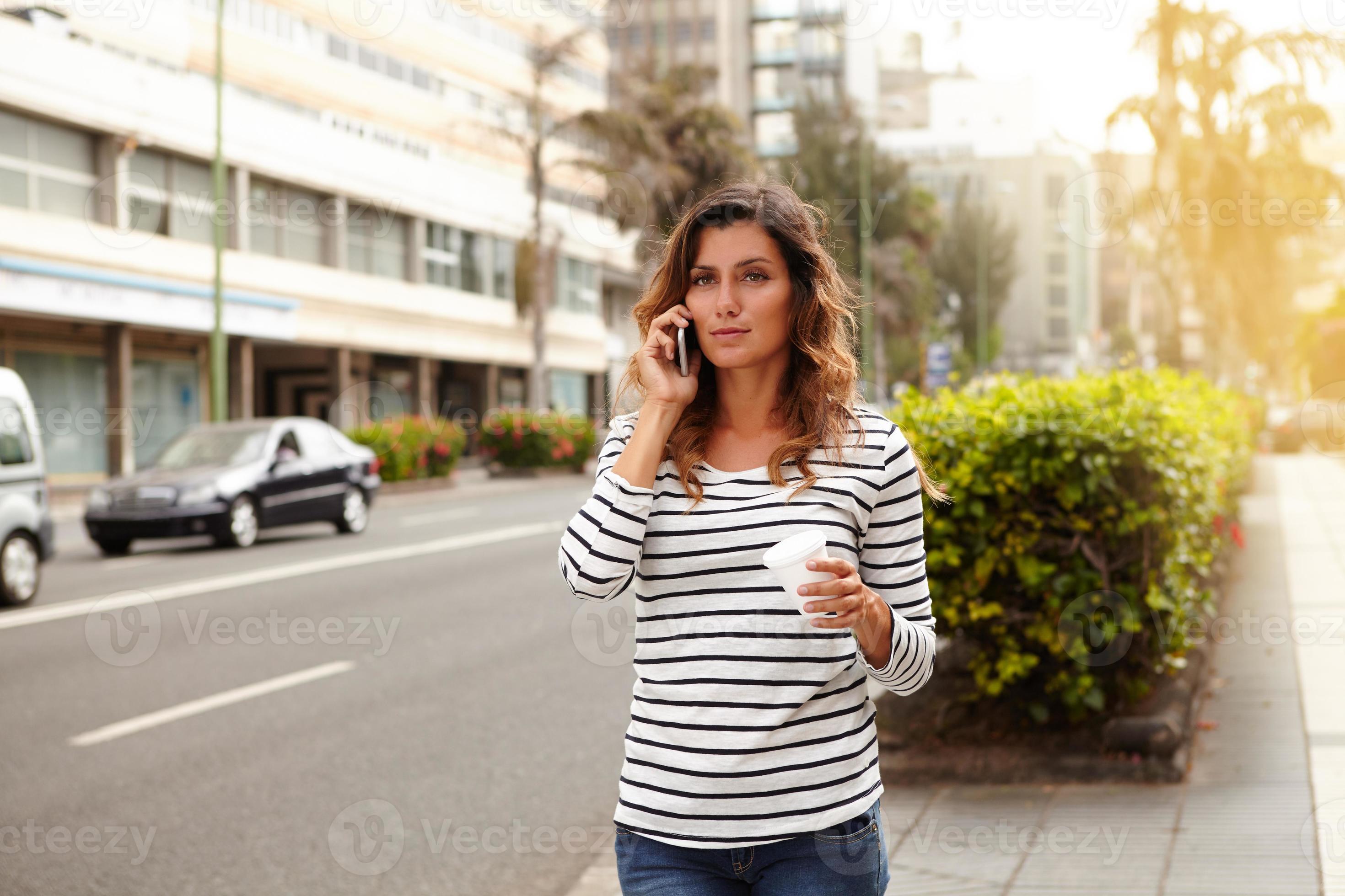 Young woman talking on mobile phone while walking 1257636 Stock Photo ...