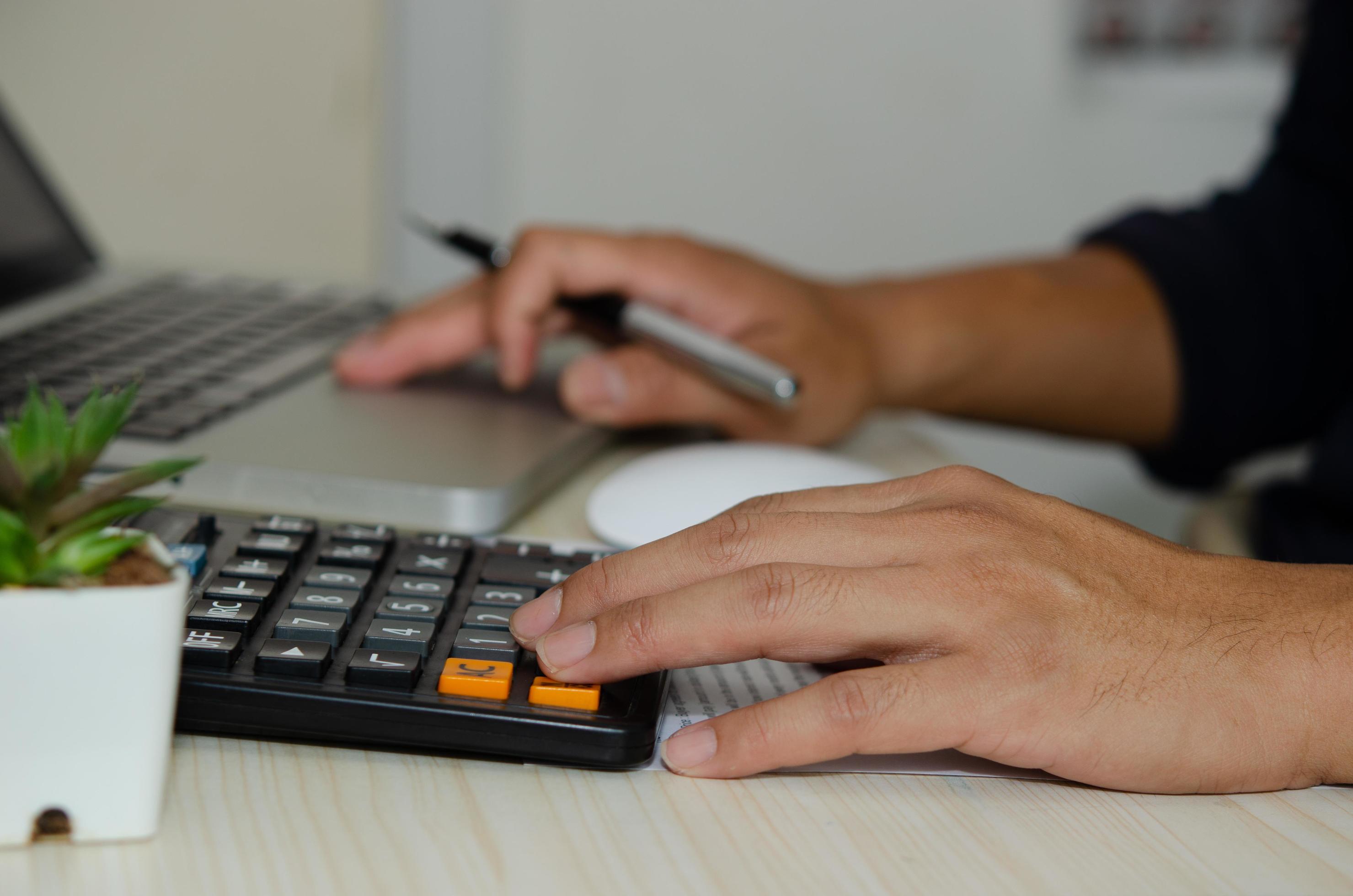 Person using a calculator at a desk 2118059 Stock Photo at Vecteezy