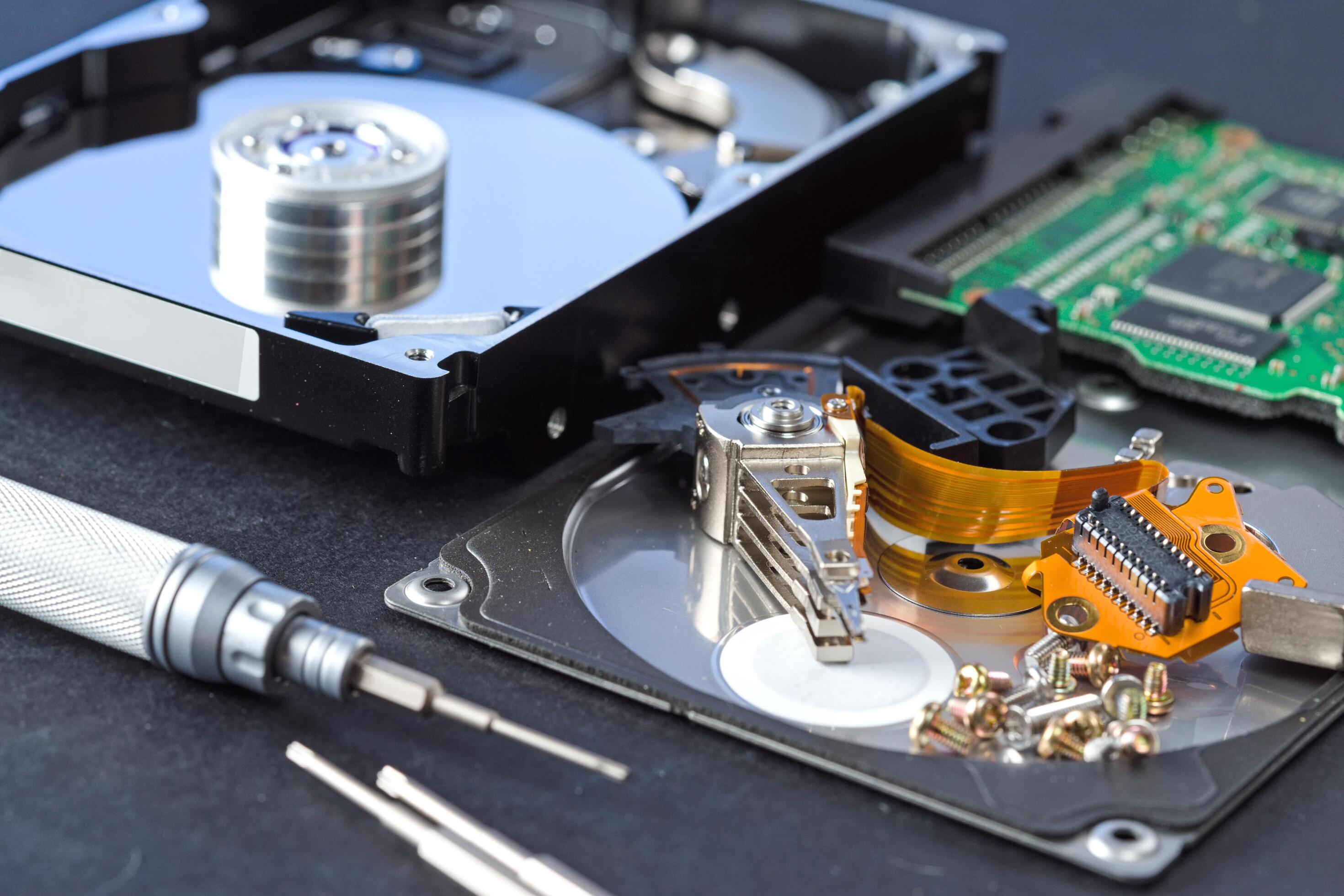 Disassembled hard disk drive inside close-up, spindle, actuator arm ... Disassembled hard disk drive inside close-up, spindle, actuator arm ...