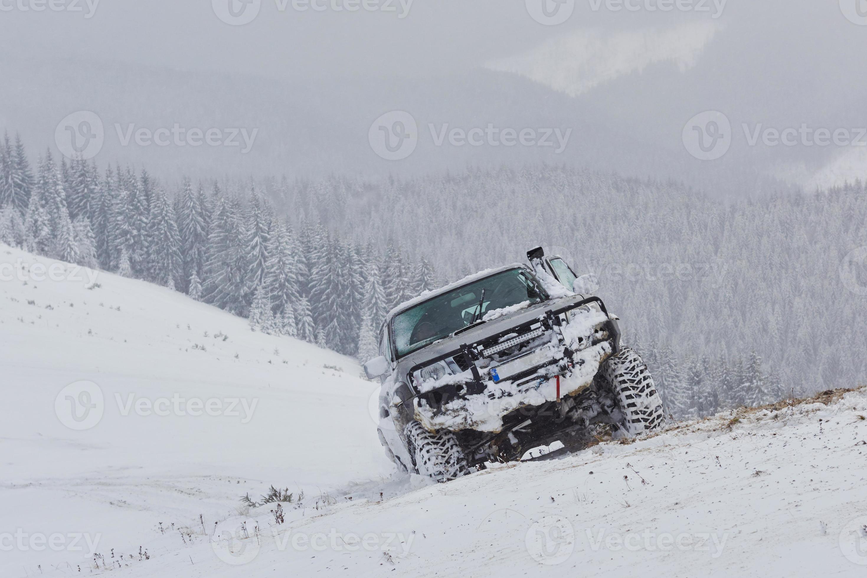 SUV rides on a winter mountians driving risk of snow and ice, drifting ...