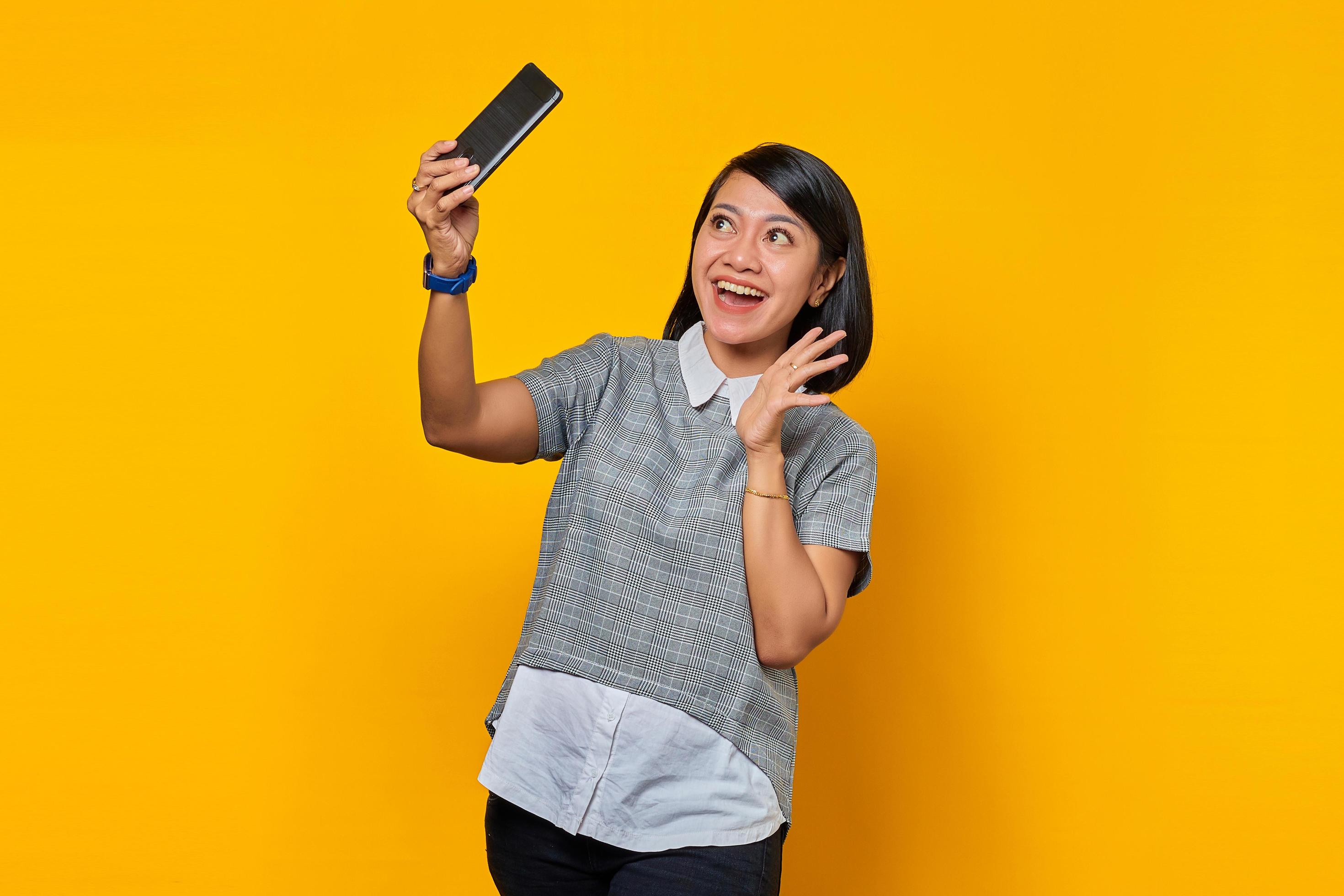 Portrait Of Excited Cheerful Young Asian Woman Using Mobile Phone Take