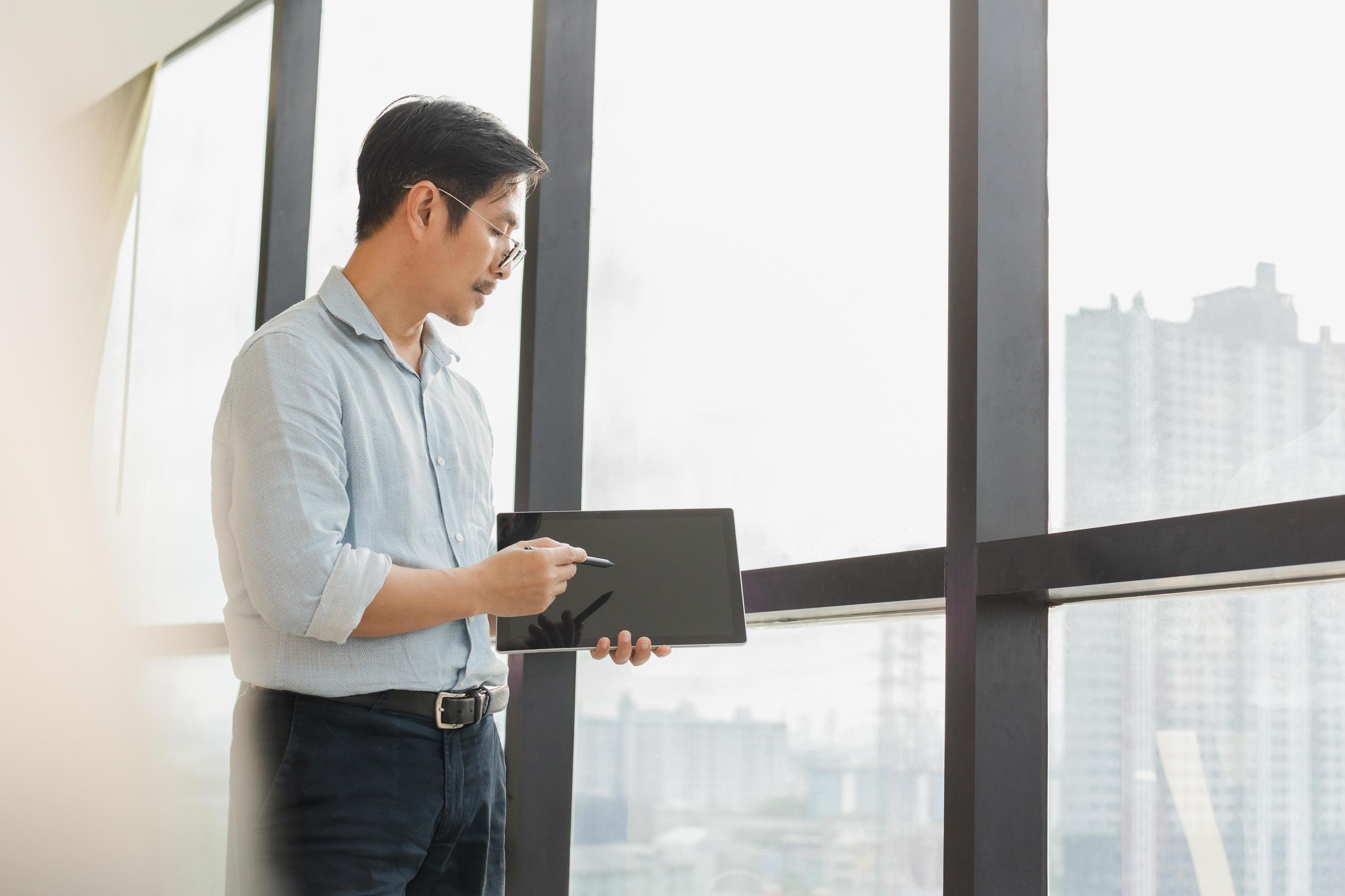 Businessman pointing tablet with digital pen at work presentation ...