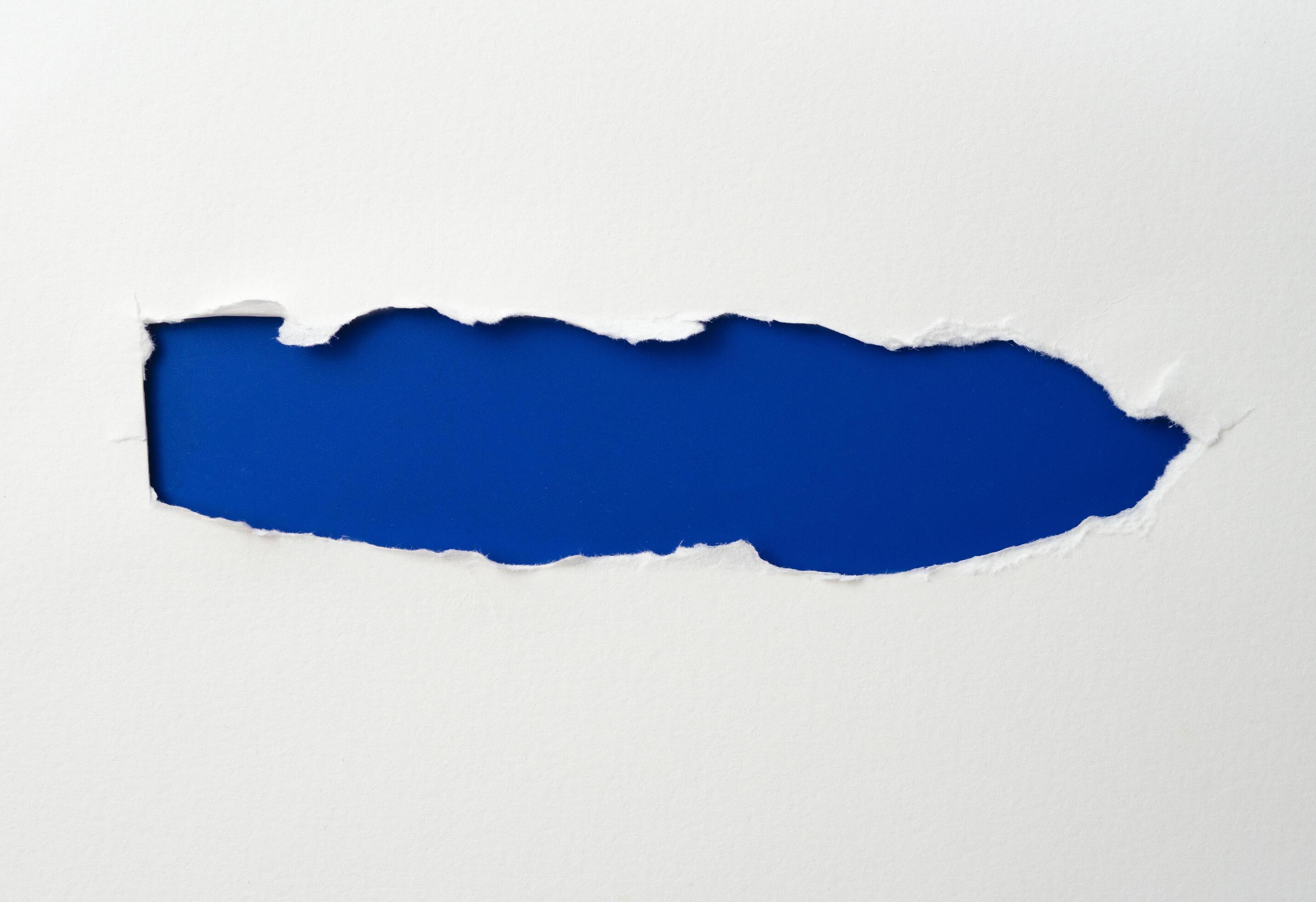 Torn Paper Frame With The Ripped Sides. A Blue Hole Of Torn On The