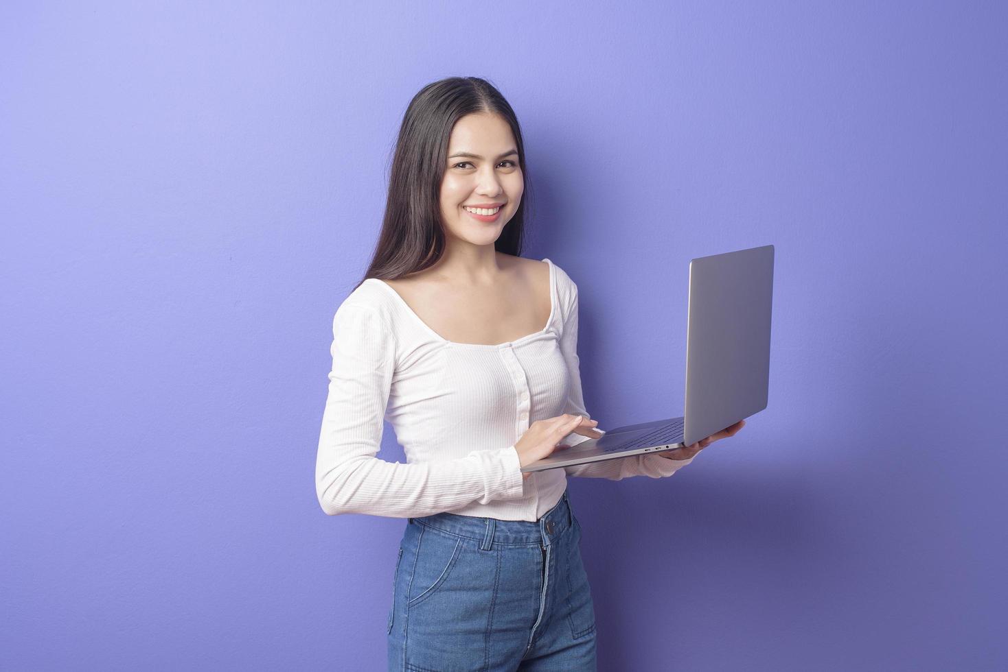 portrait of young beautiful smiling woman is holding laptop over ... portrait of young beautiful smiling woman is holding laptop over ...