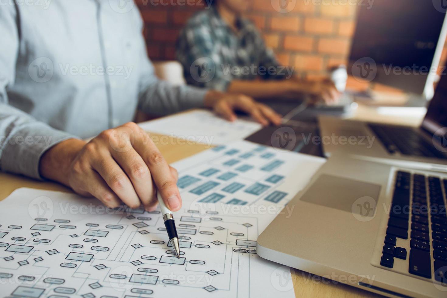 Software Developer Is Pointing To The Paper Working And Analyzing