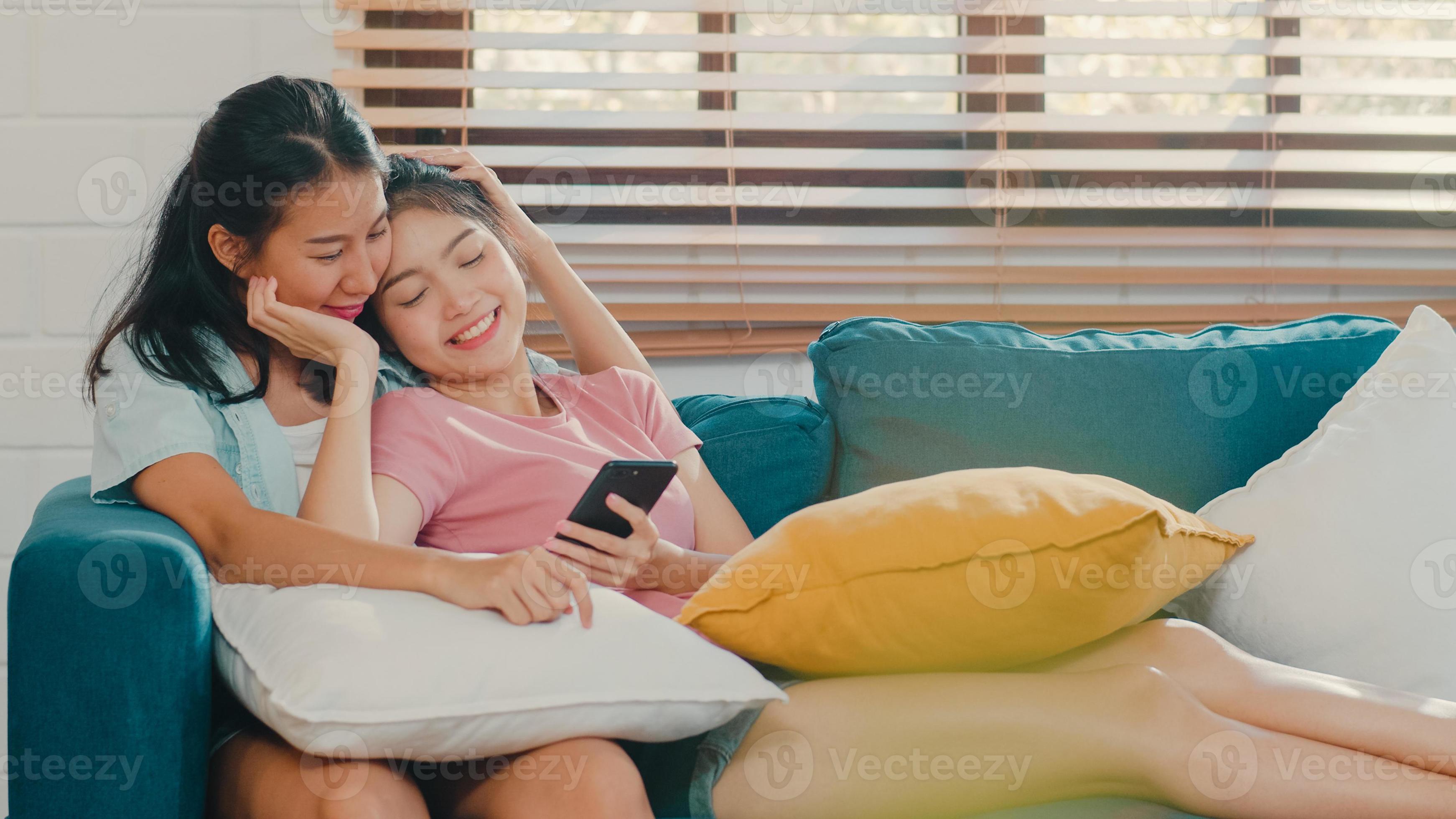 Young Lesbian Lgbtq Women Couple Using Mobile Phone At Home Asian