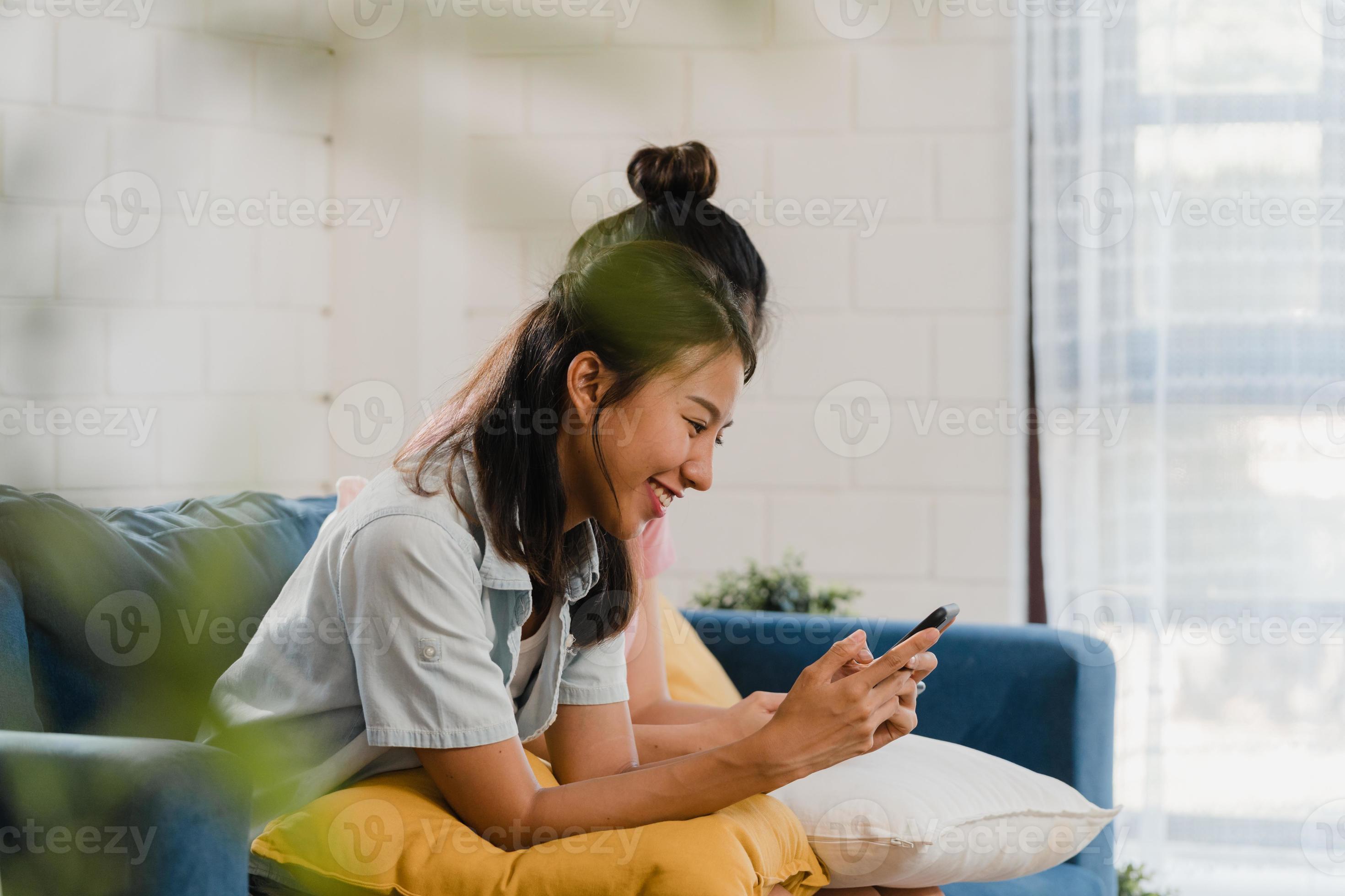 Young Lesbian Lgbtq Women Couple Using Mobile Phone At Home Asian