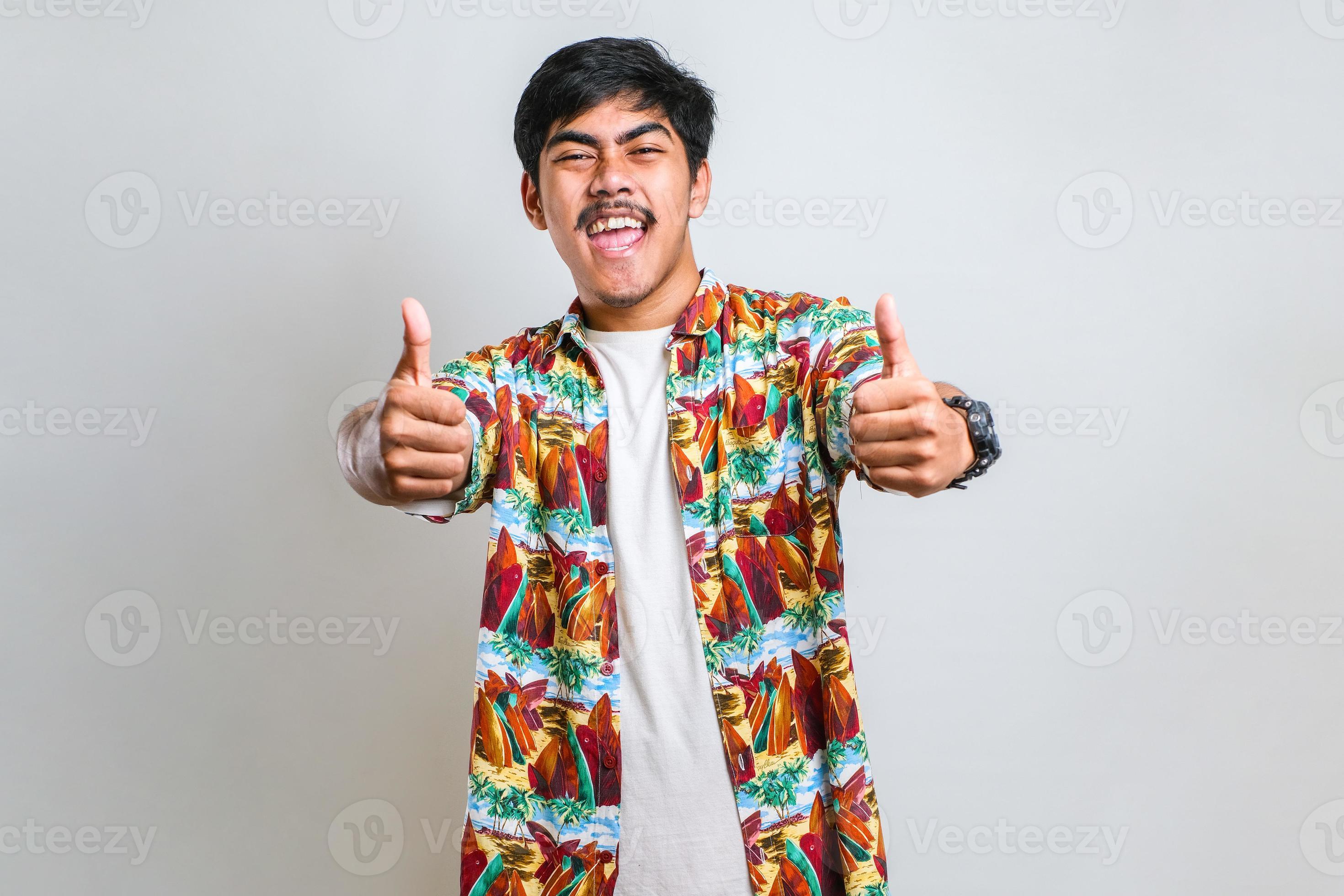 Asian man doing thumbs up smiling and happy for success. Winner gesture ...