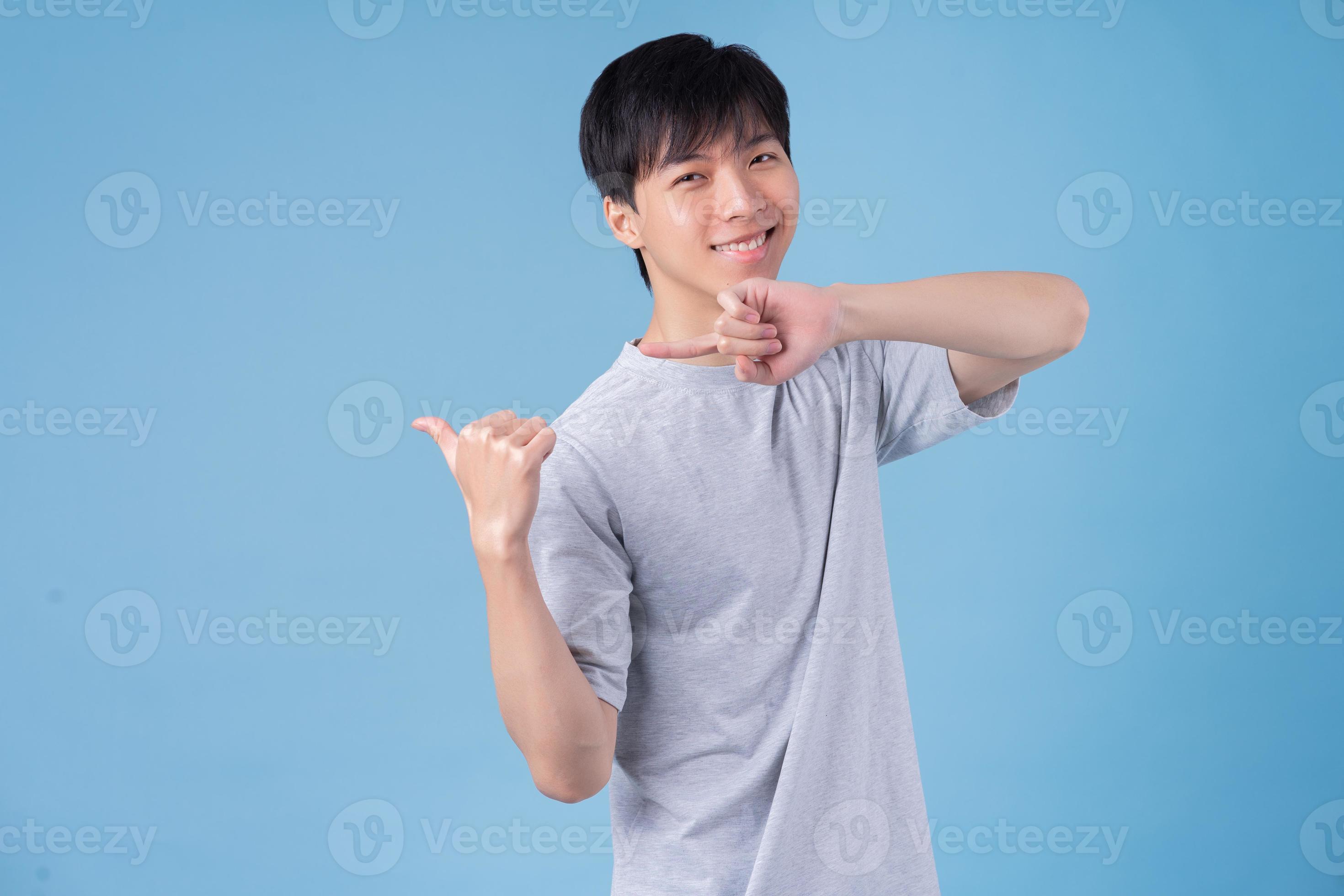 Young Asian man posing on blue background 5923001 Stock Photo at Vecteezy