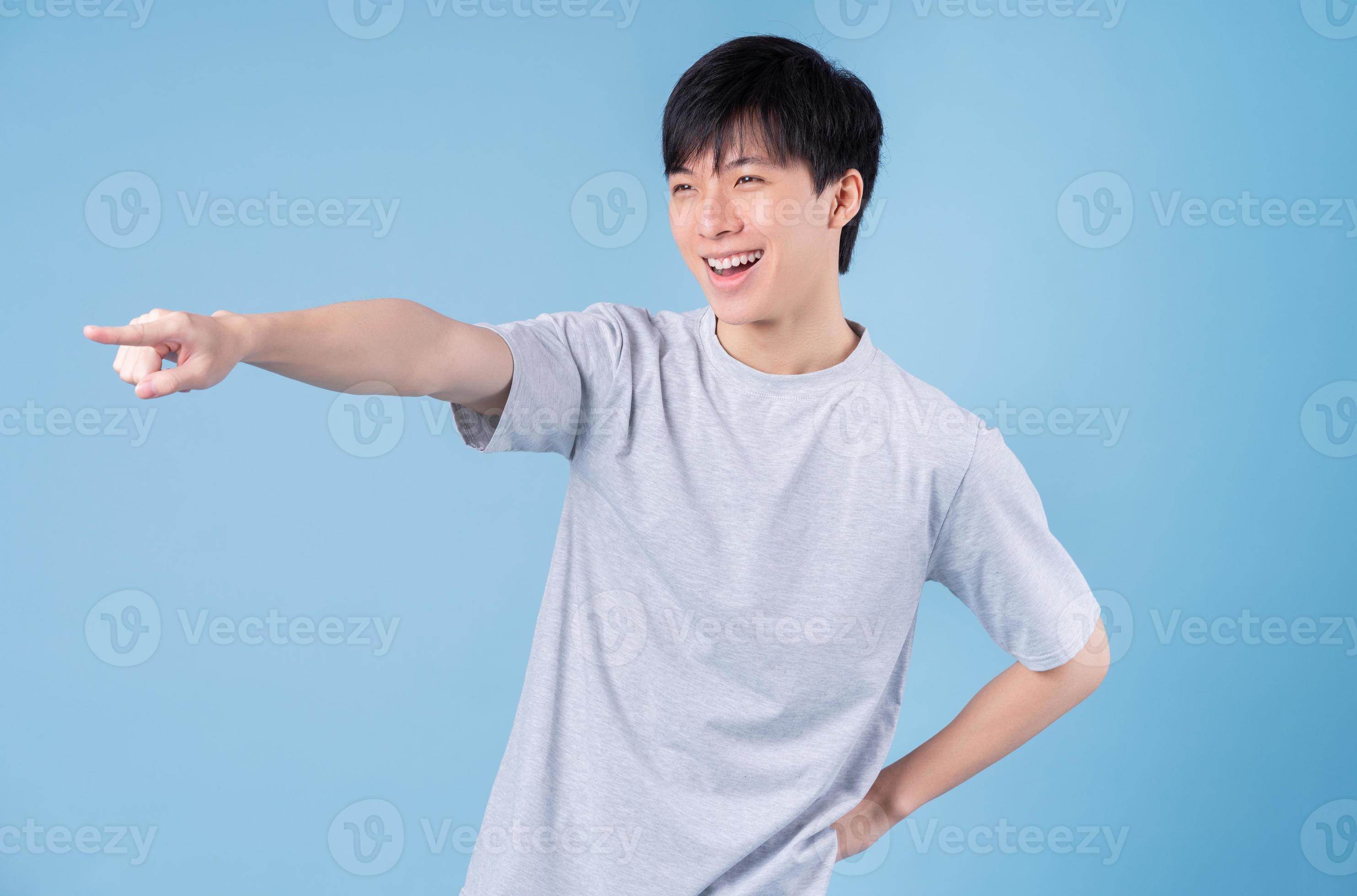 Young Asian man posing on blue background 5923208 Stock Photo at Vecteezy