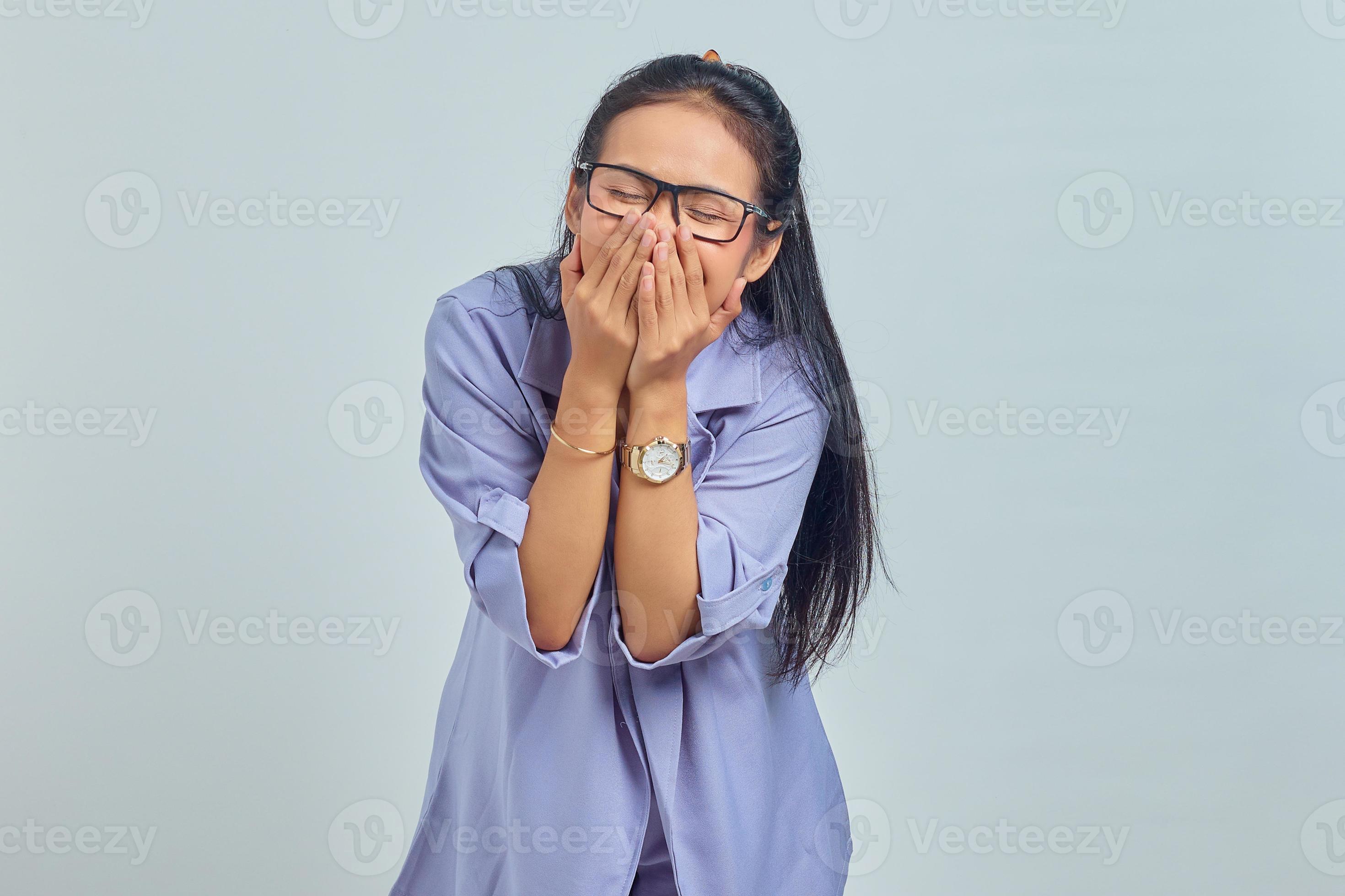 Portrait Of Laughing Young Asian Woman Covering Mouth With Hand On
