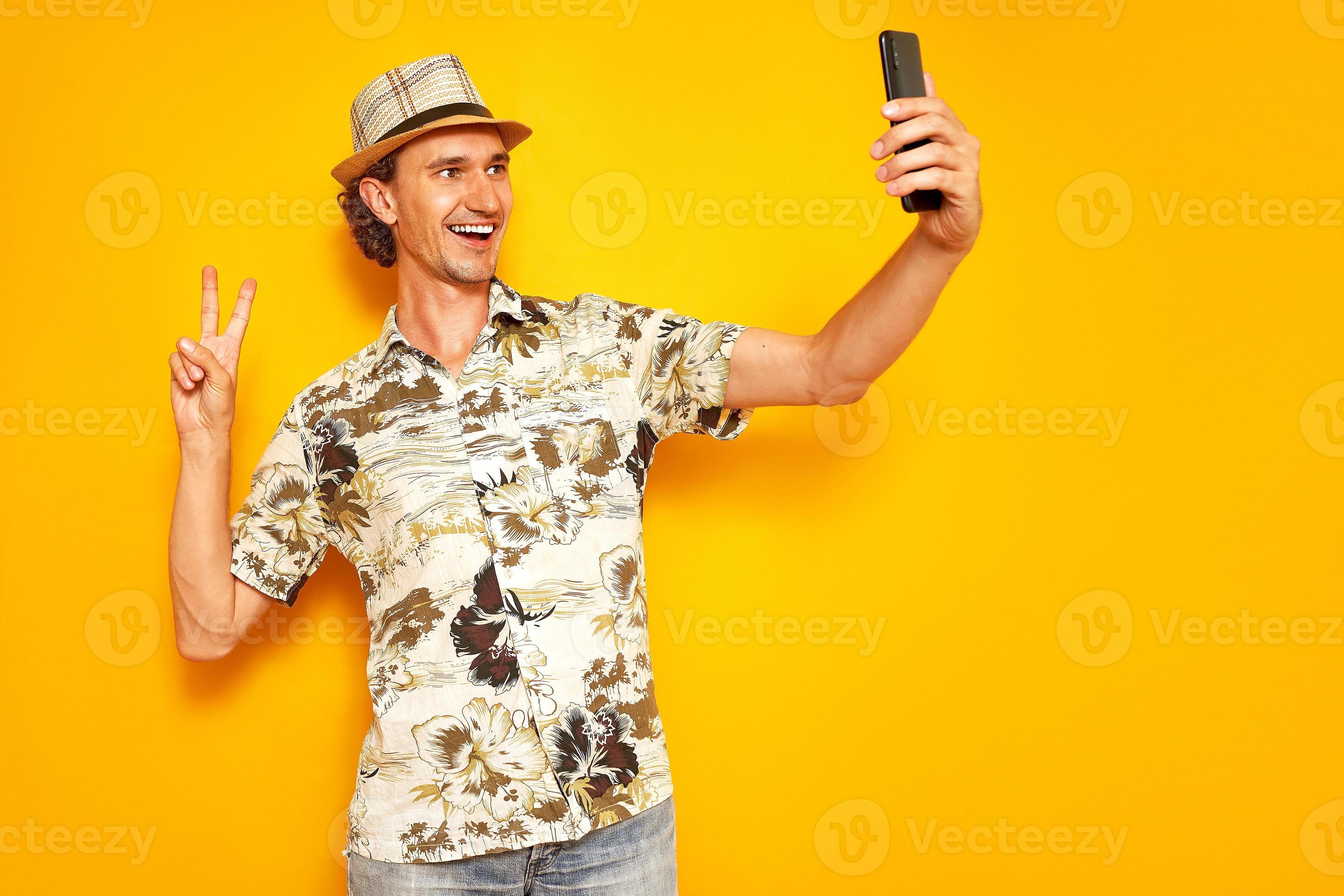 happy male tourist traveler with phone in his hand takes selfie ...