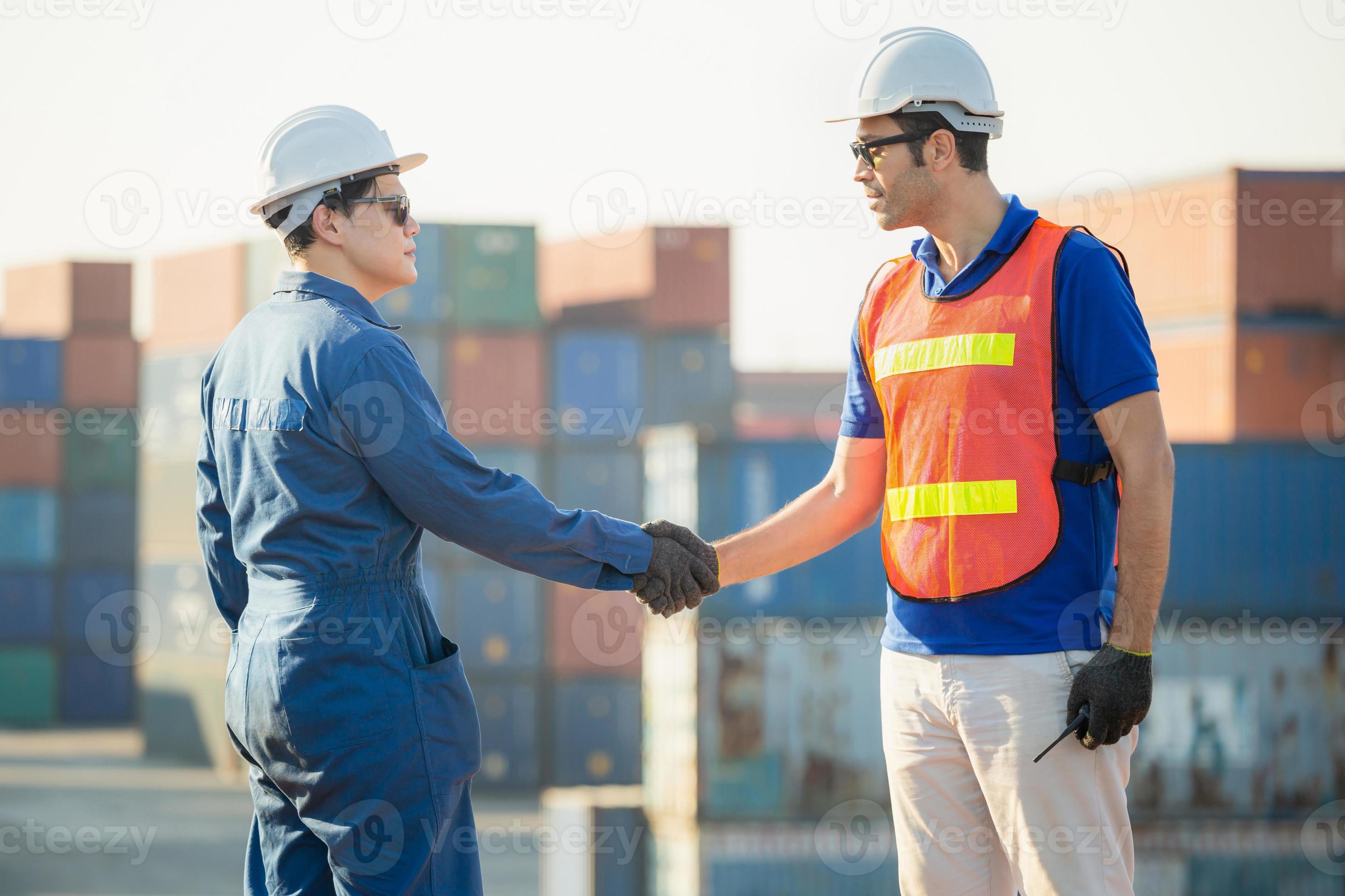 Engineer And Worker Handshake With Blurred Containers Cargo Background