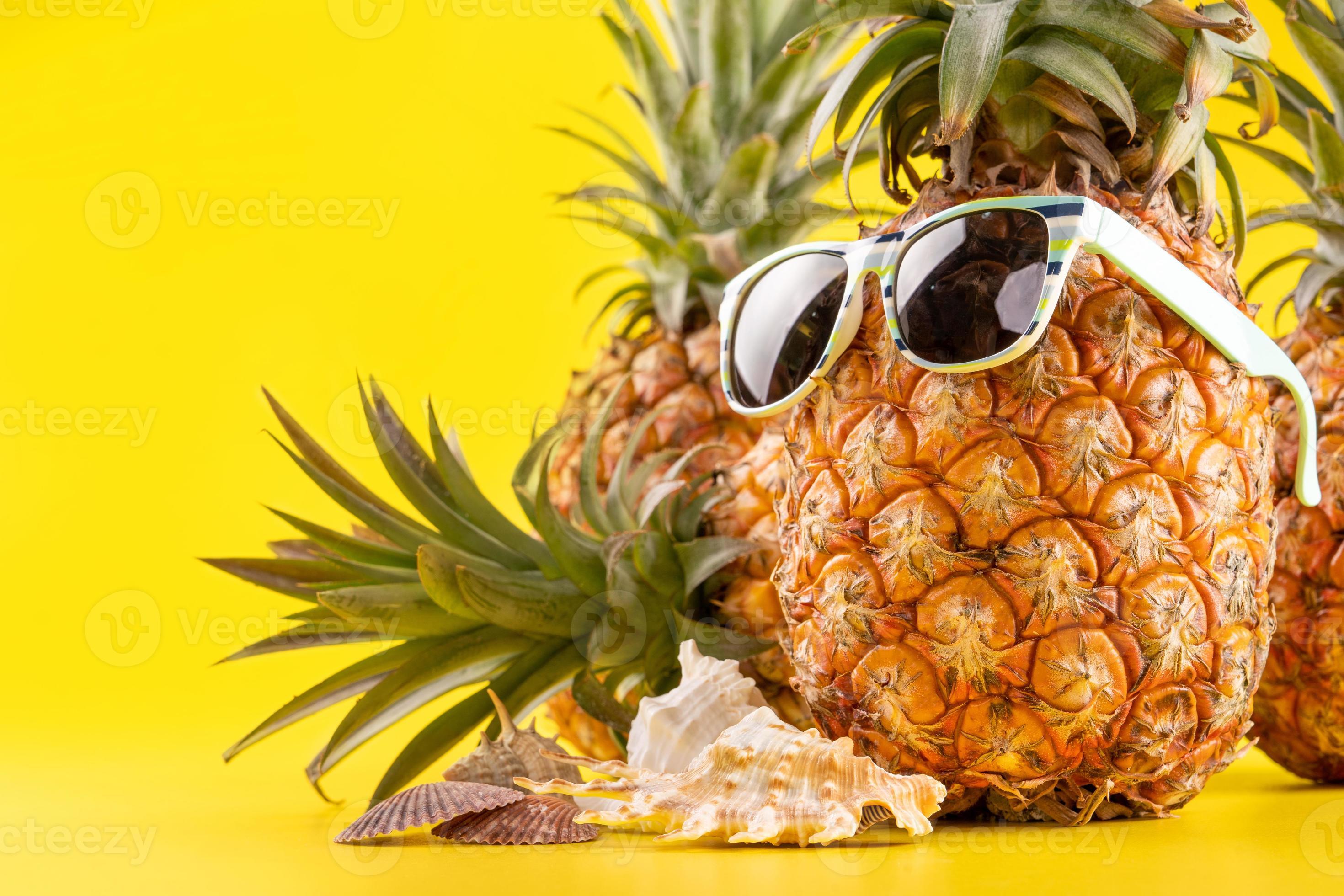 Creative pineapple looking up with sunglasses and shell isolated on ...