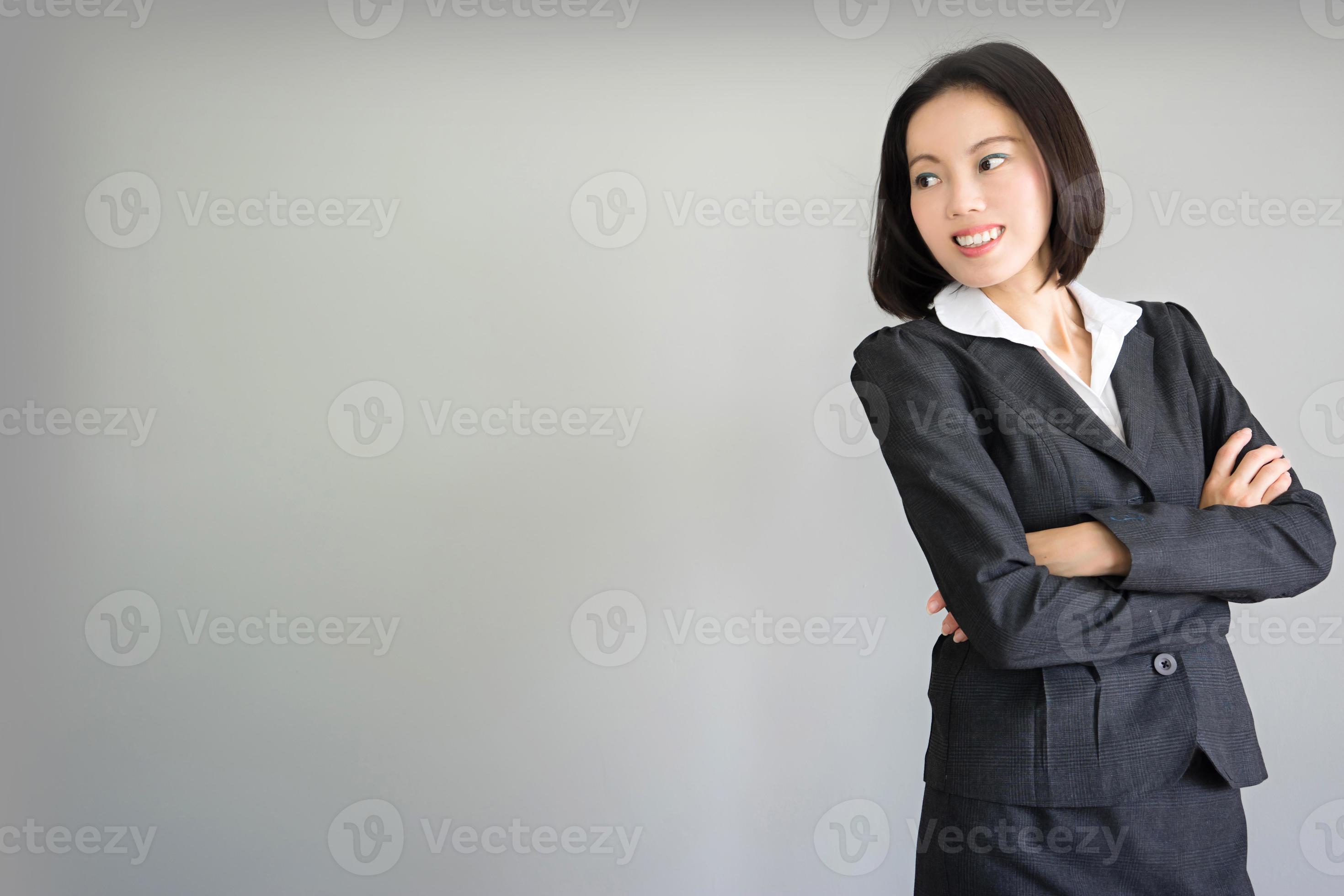 Portrait young business woman standing against grey background 6902816 ...