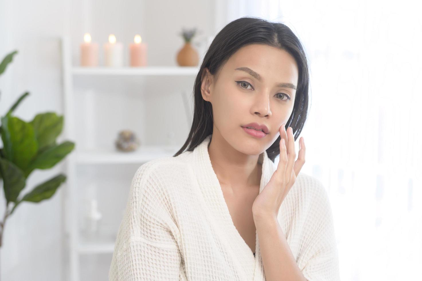 Happy Beautiful Woman In White Bathrobe Applying Moisturizing Cream On