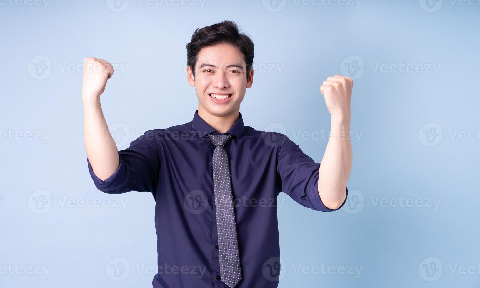 Full length image of young Asian businessman on blue background 6971692 ...