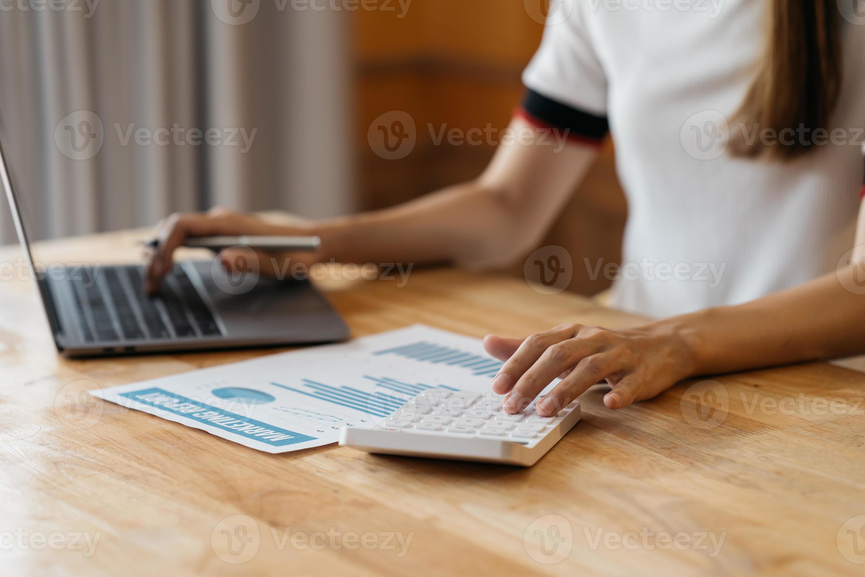 Close up woman hand using calculator and writing make note with ...