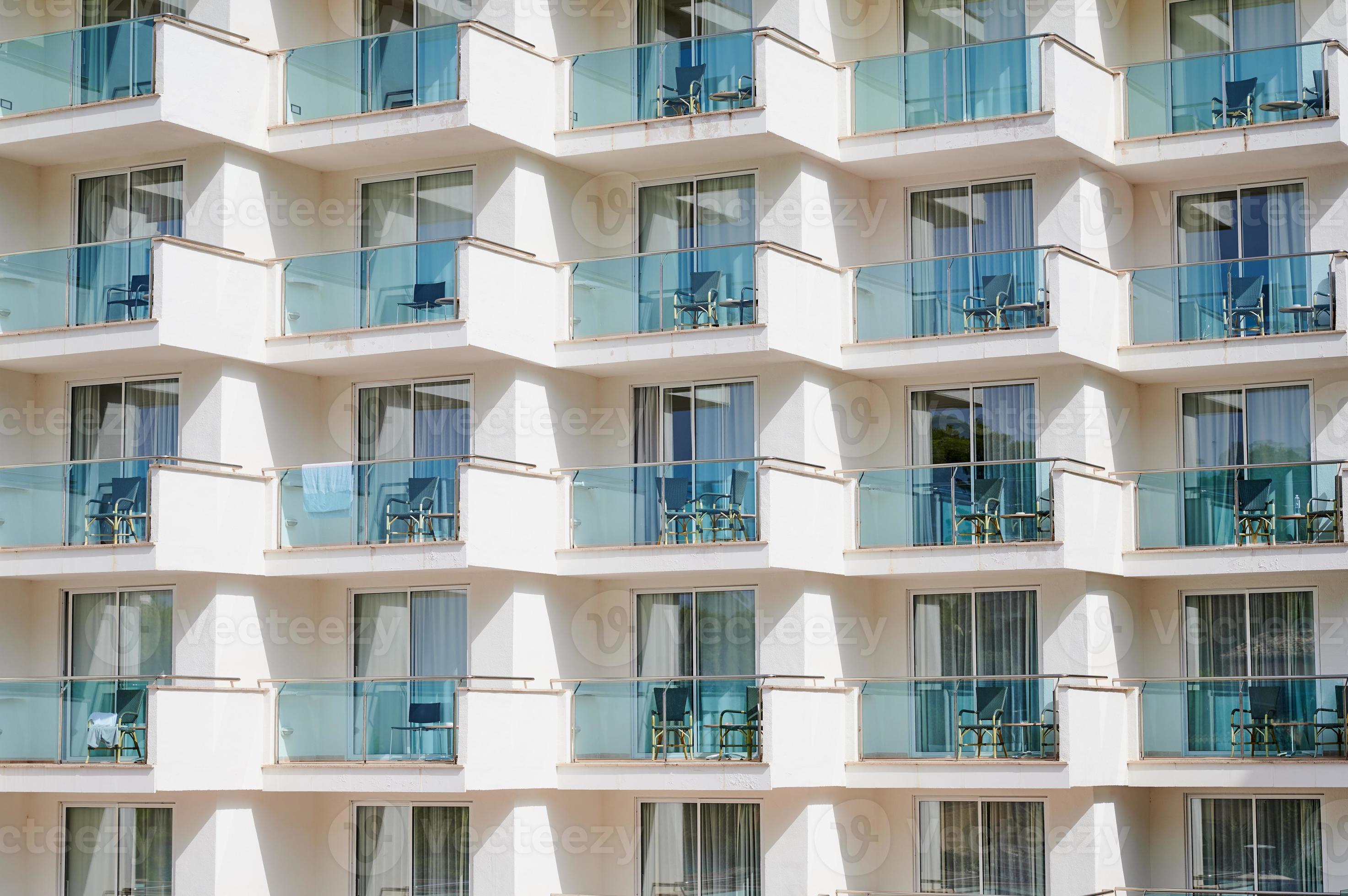 Pattern of hotel room balconies with chairs in the sunshine 7185673 ...