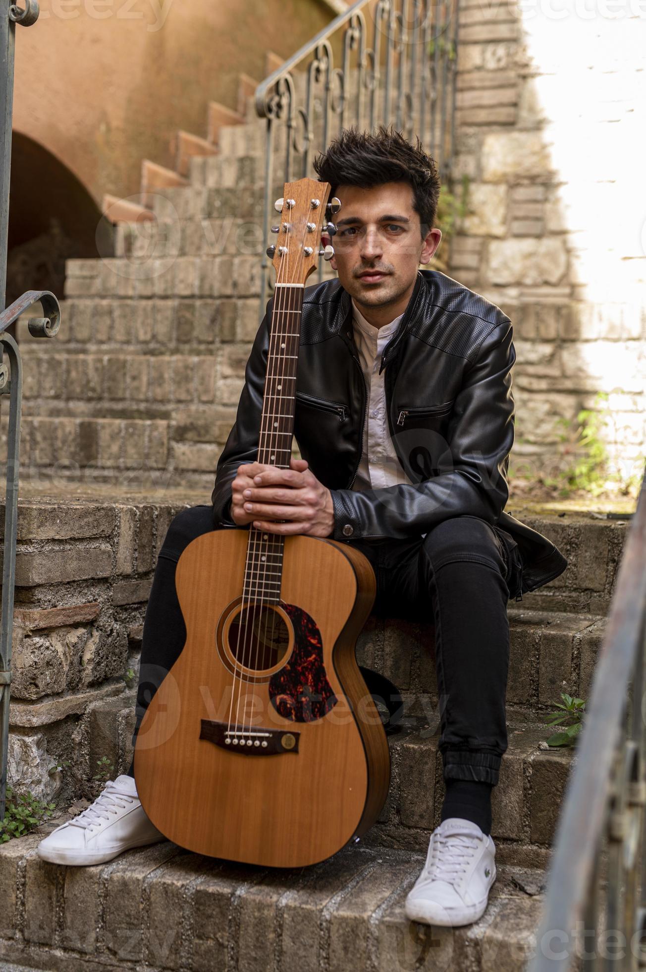 boy holding guitar outdoors posing 7306344 Stock Photo at Vecteezy