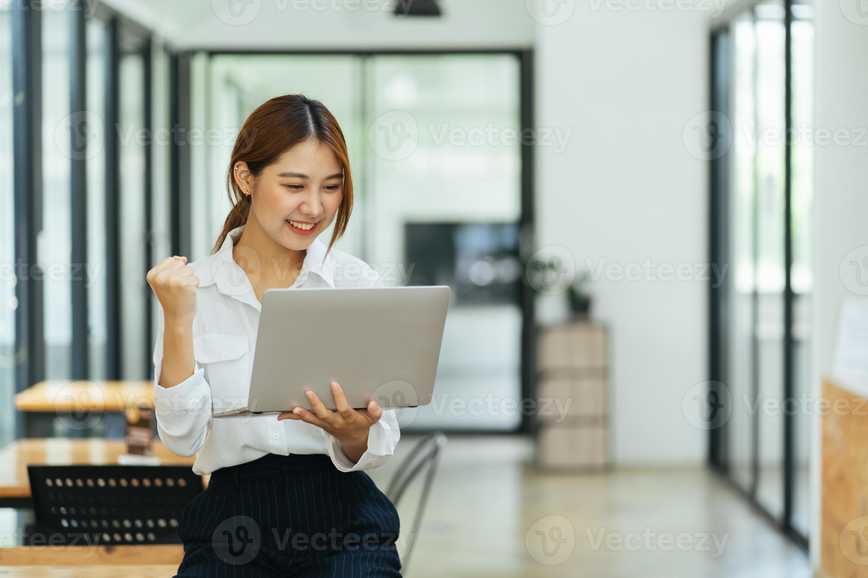 Young woman with laptop expressing excitement in home office, Excited ...