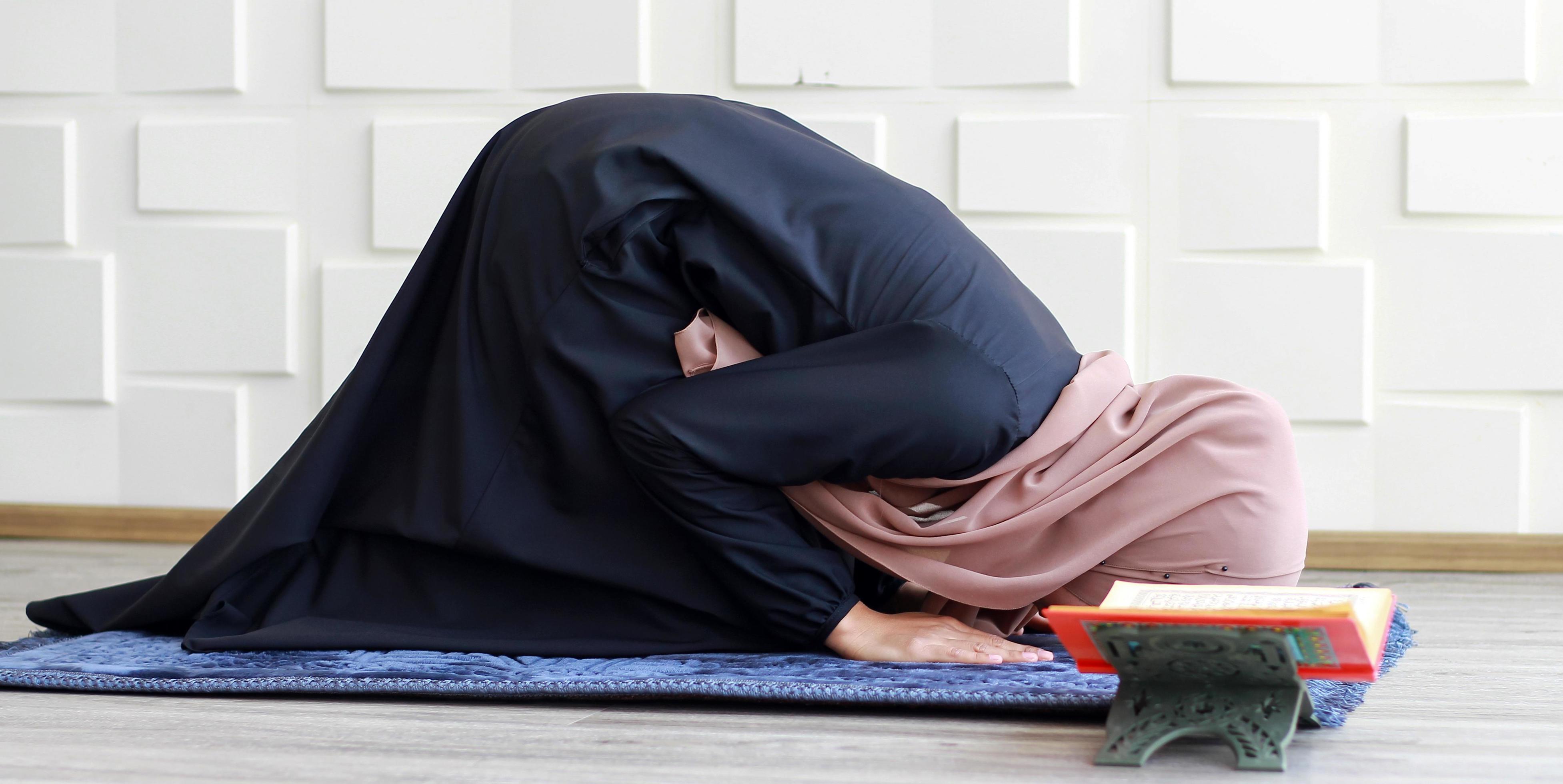 young muslim woman dressed in black hijab, praying for Allah, copy ...