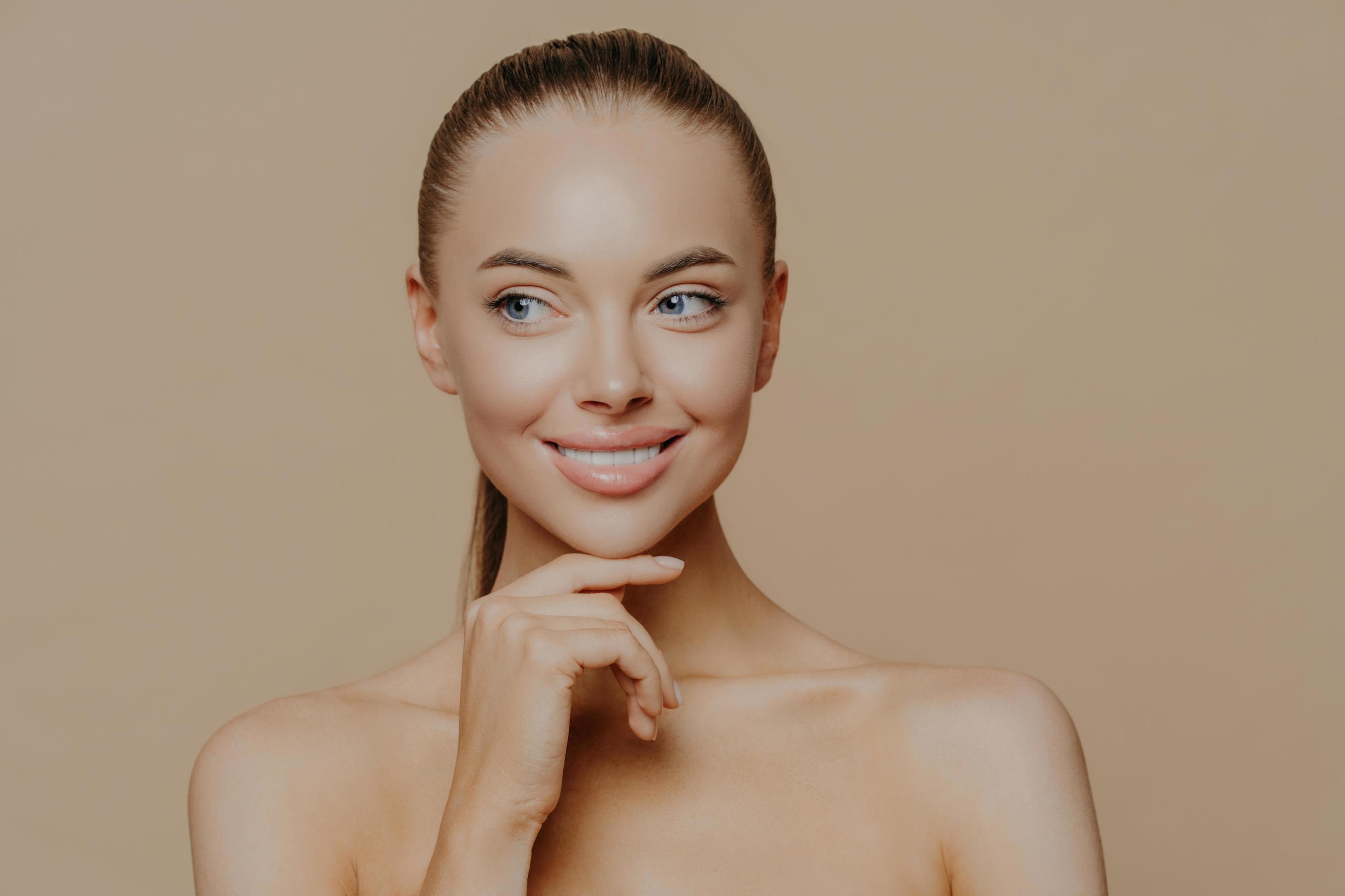 Smiling Well Groomed Young Woman With Beauty Face Care Healthy Glowing Skin Touches Chin