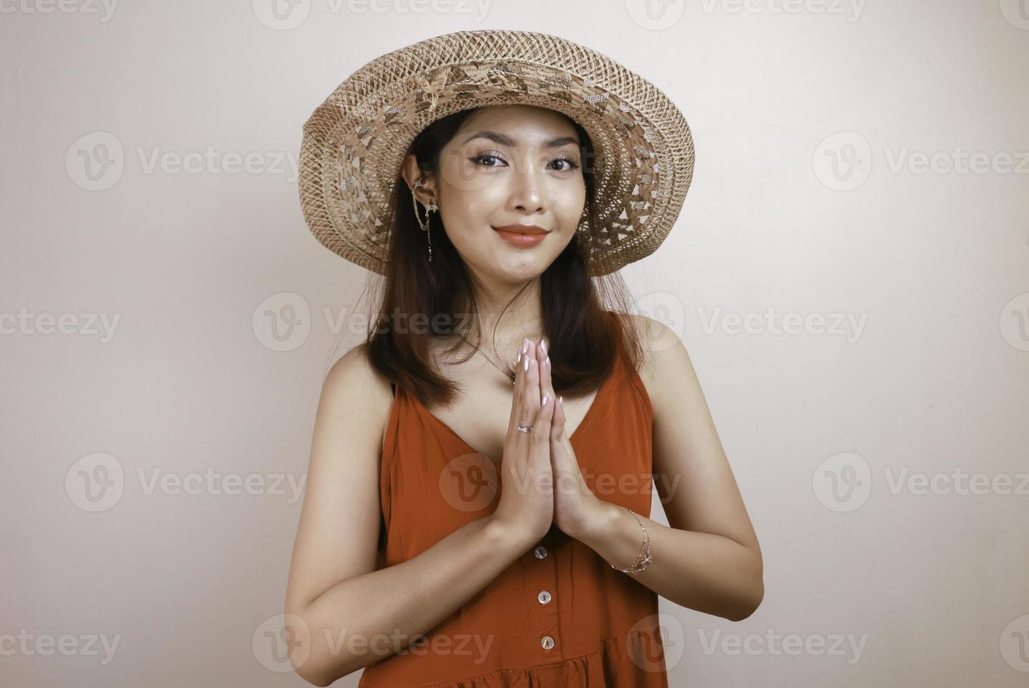 A Young Beautiful Asian Woman Wearing A Straw Hat Gives Greeting Hands