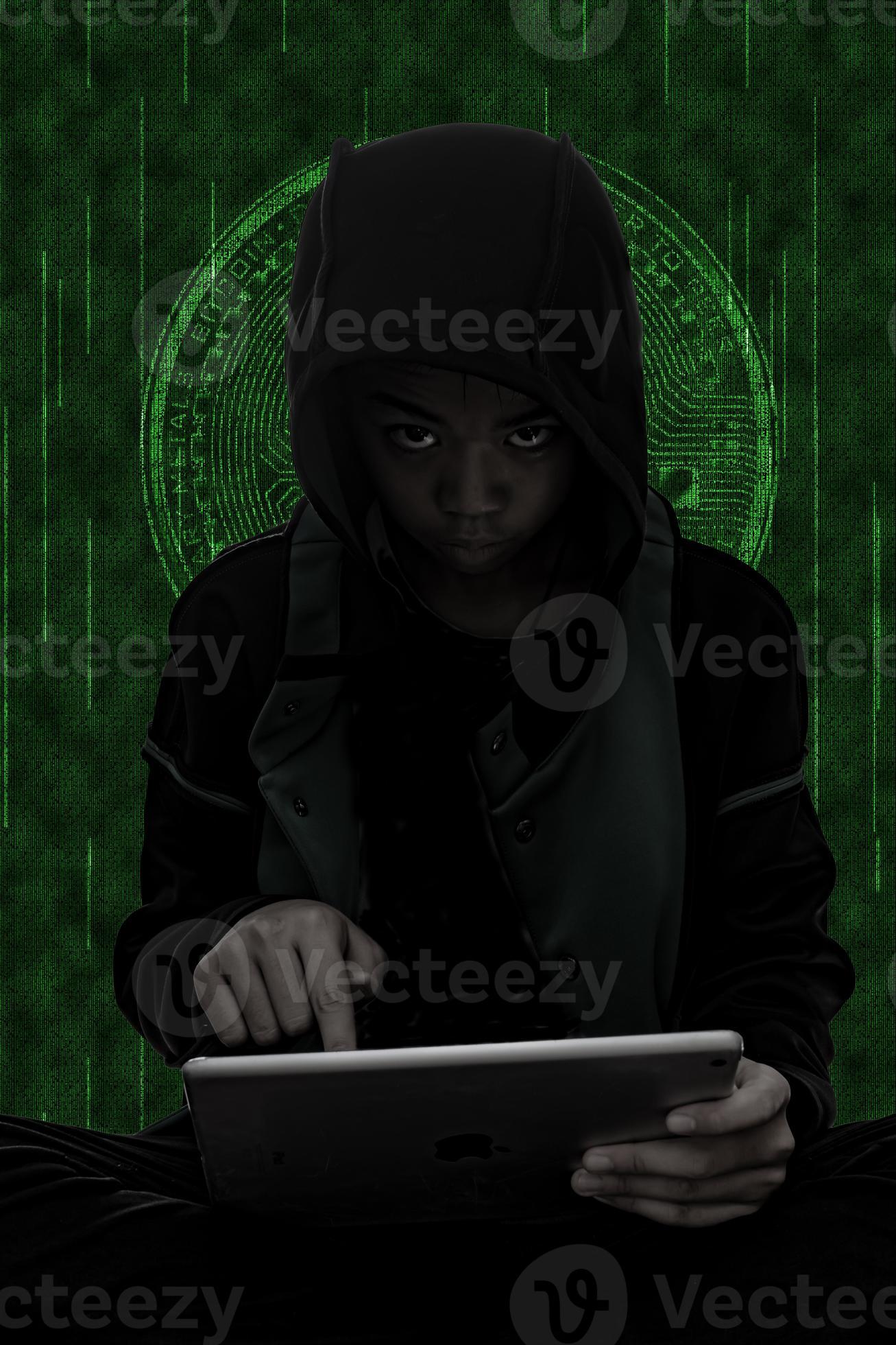 Hacker boy are hacking through the tablet on green symbols background ...