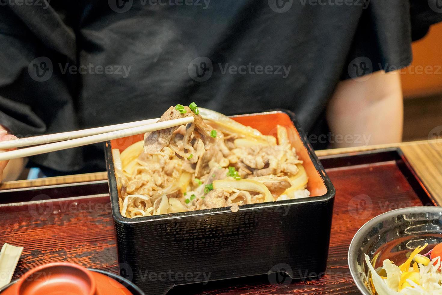Asian Woman ready to eat Japanese food grilled beef meal with rice, Gyu Donburi in bento box ...