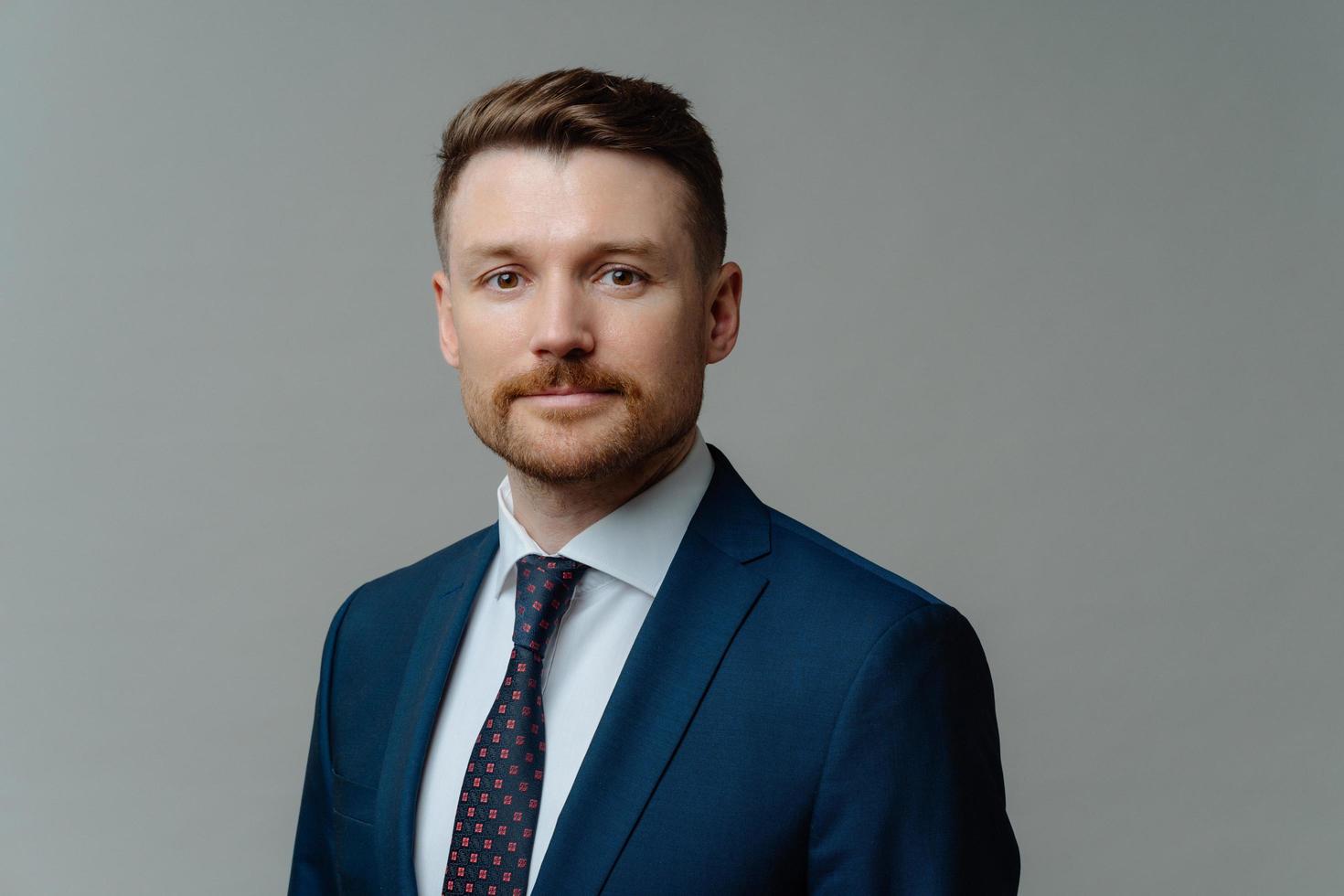 Handsome unshaven man in suit posing against grey background 8241920 ...