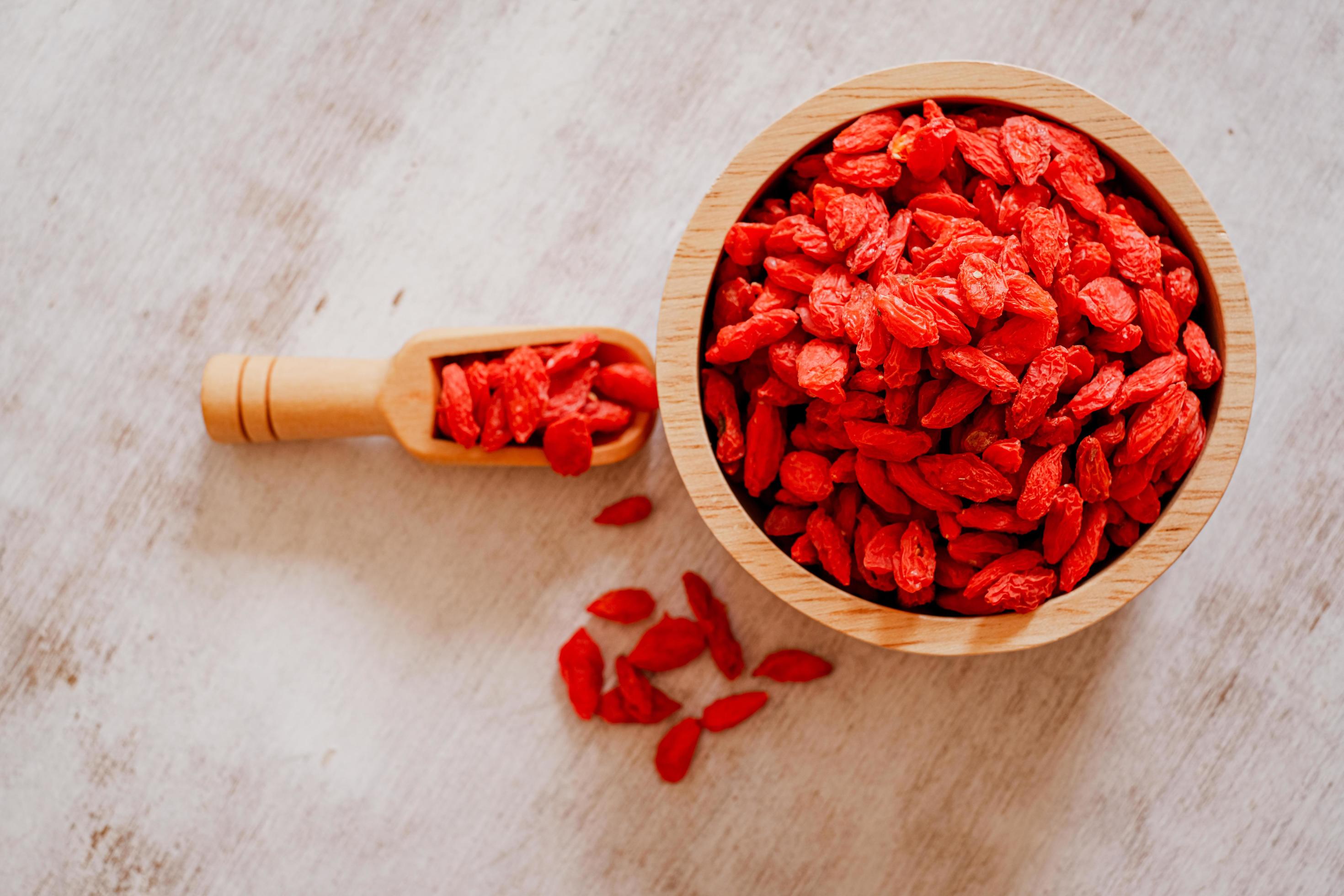 Dried Chinese wolfberries or Goji berry chinese herb or Matrimony vine in the woodden scoop on ...