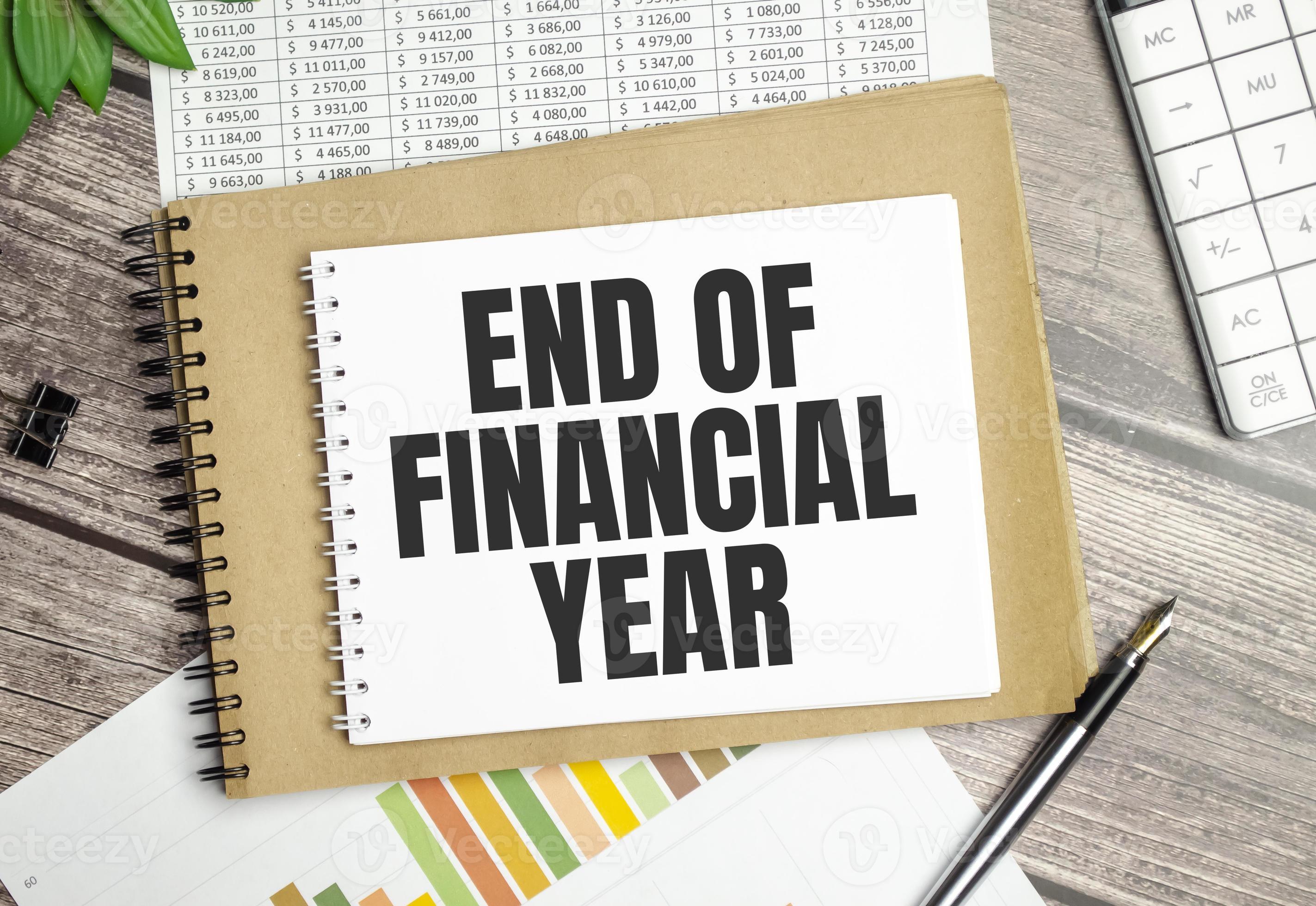 Text End of Financial Year on a notebook on the diagram and charts with ...