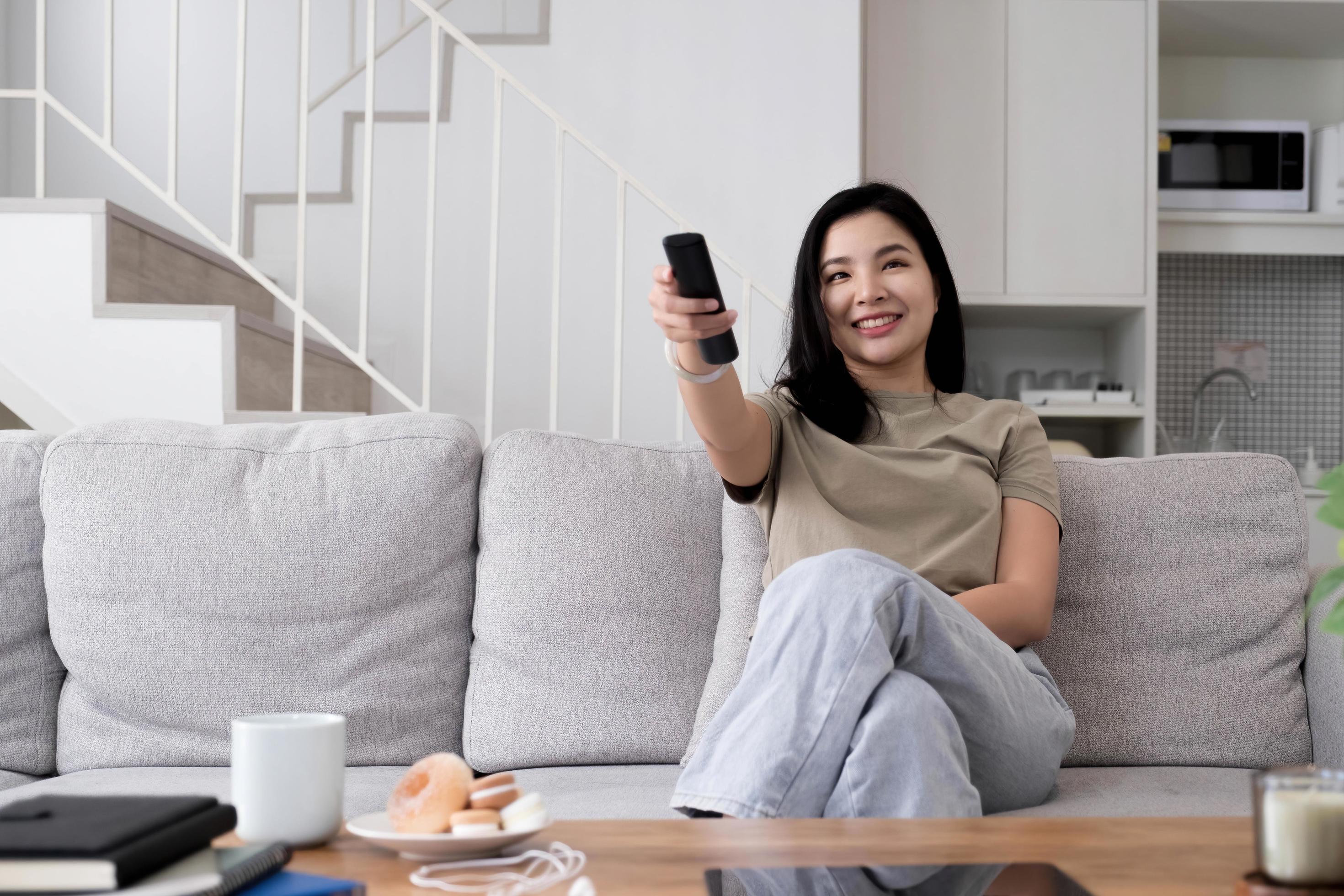 Asian Young Beautiful Woman Watching Fun Movie On Television At Home