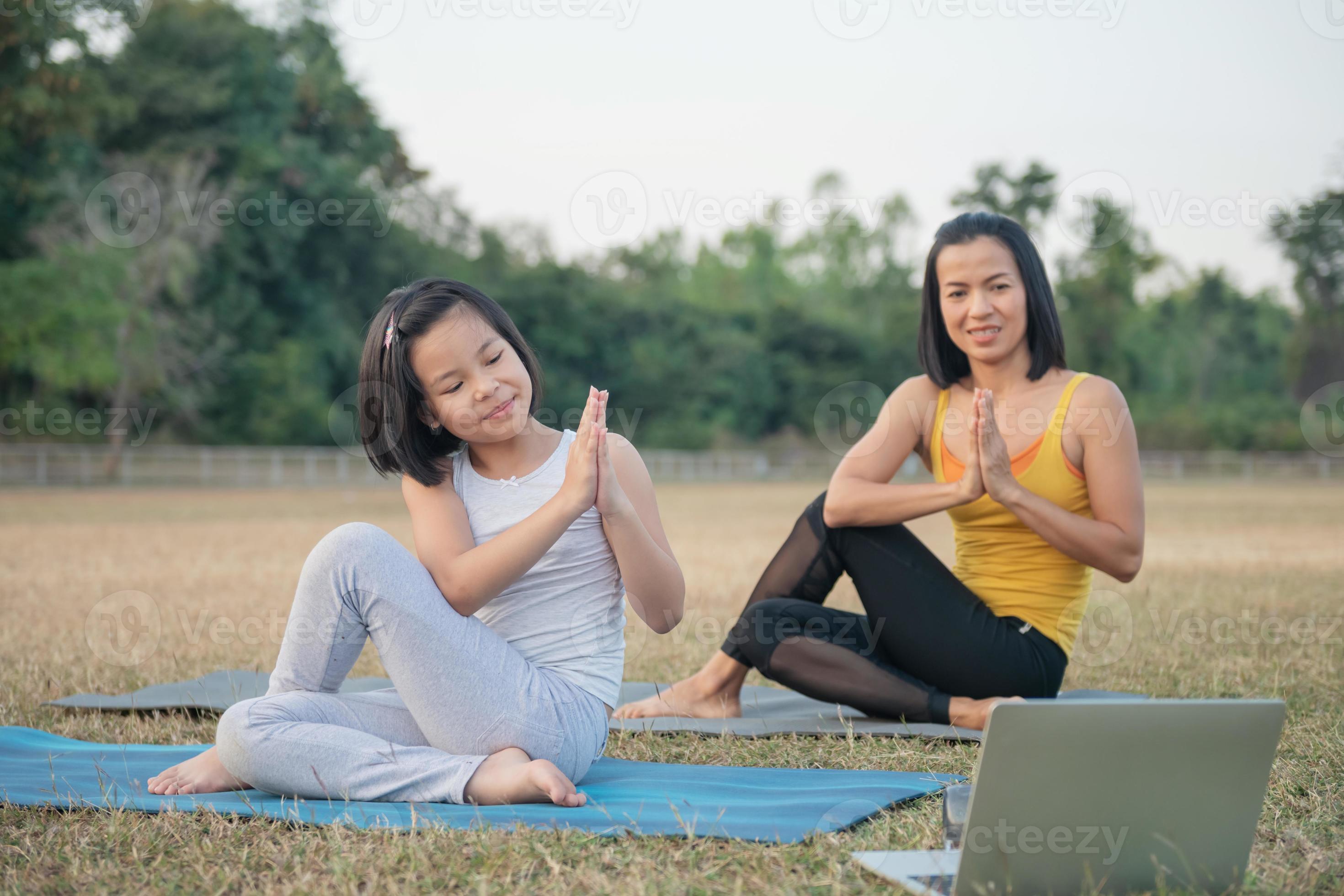 Mother and daughter doing yoga. woman and child training in park. outdoor sports. healthy sport ...