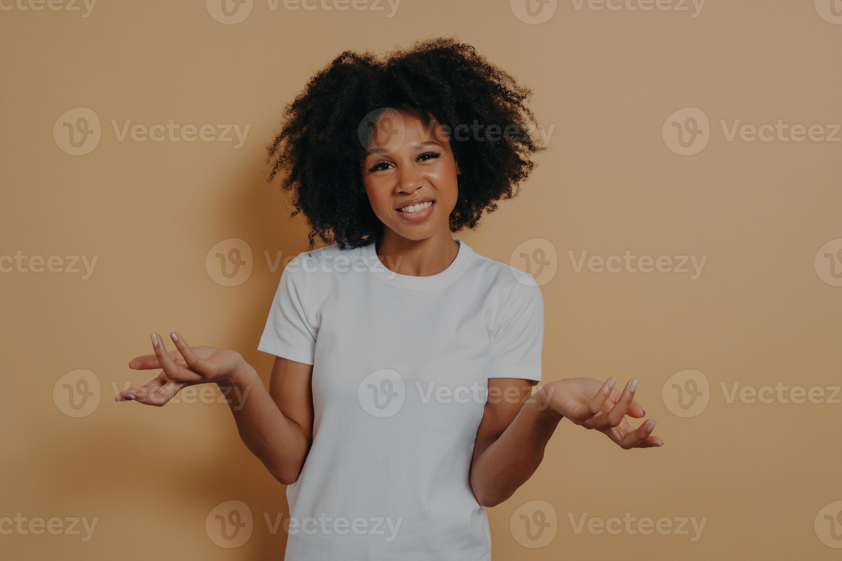 Confused african female can not make decision, shrugging shoulders ...