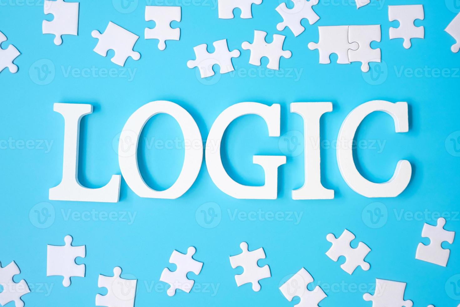 LOGIC text with white puzzle jigsaw pieces on blue background. Concepts ...