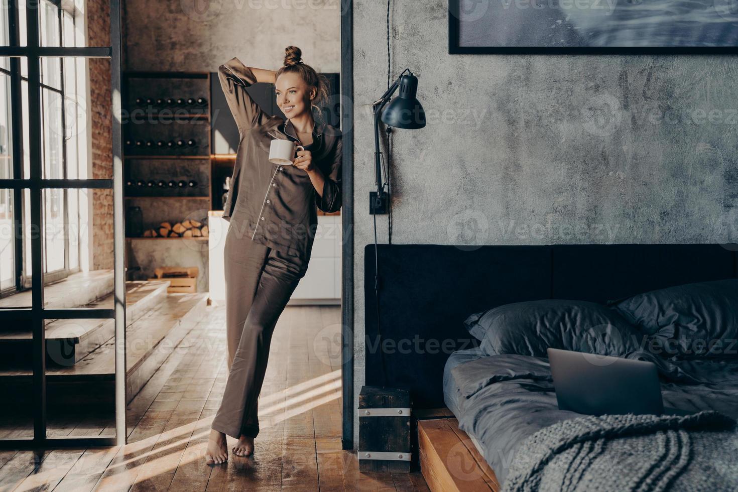 Young Pretty Slim Woman Wearing Brown Satin Pajama Holding Coffee Cup