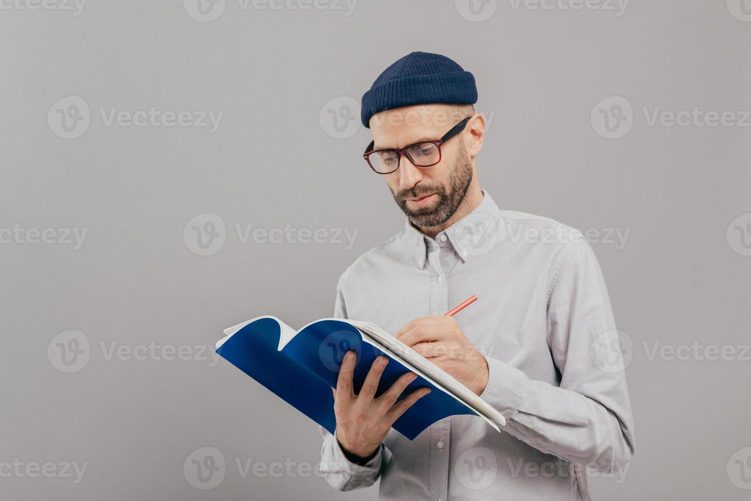 Serious male teacher writes down notes for next class, holds notepad ... Serious male teacher writes down notes for next class, holds notepad ...