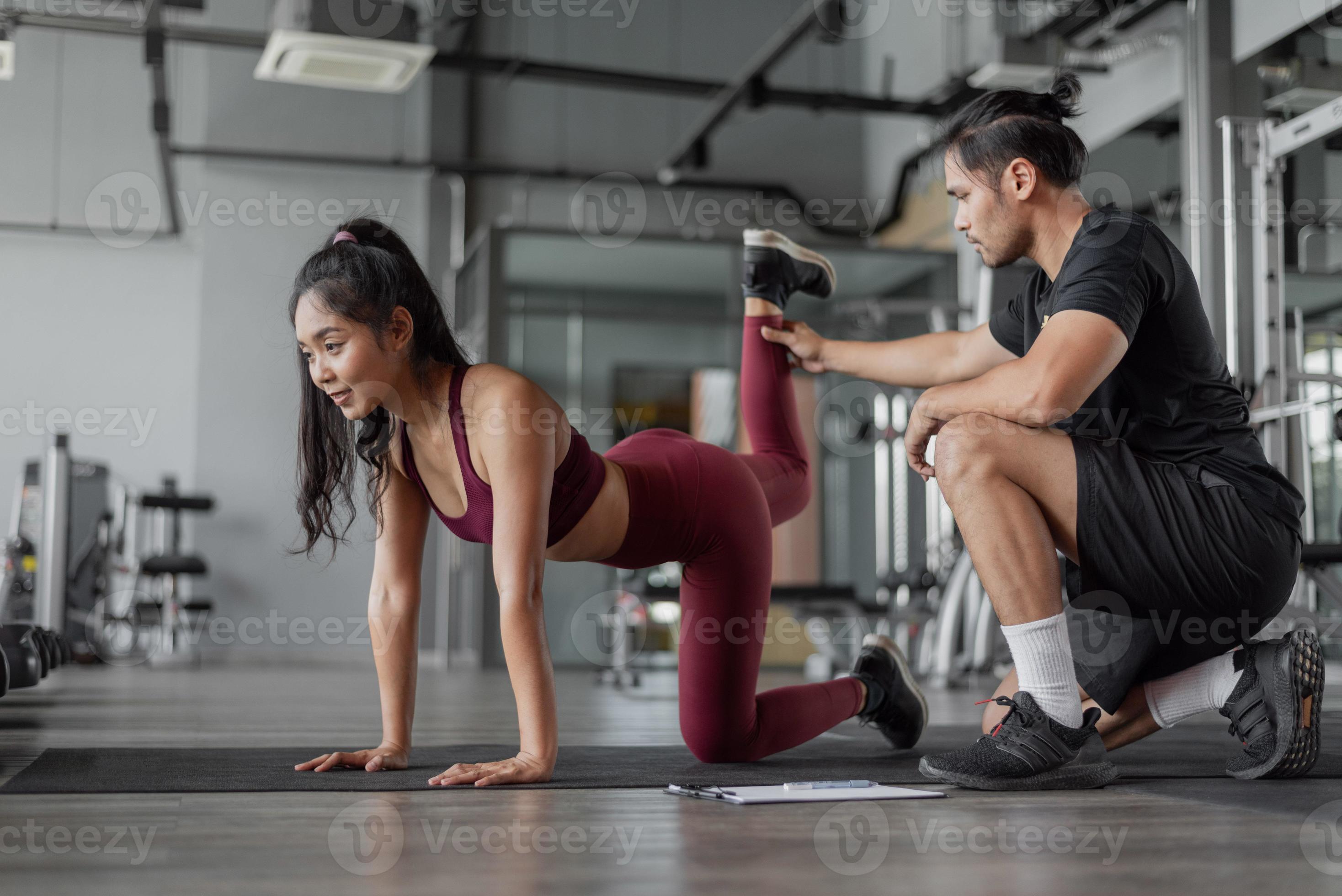 ejercicio de mujer asiática con entrenador personal en el gimnasio. joven mujer sana haciendo ...