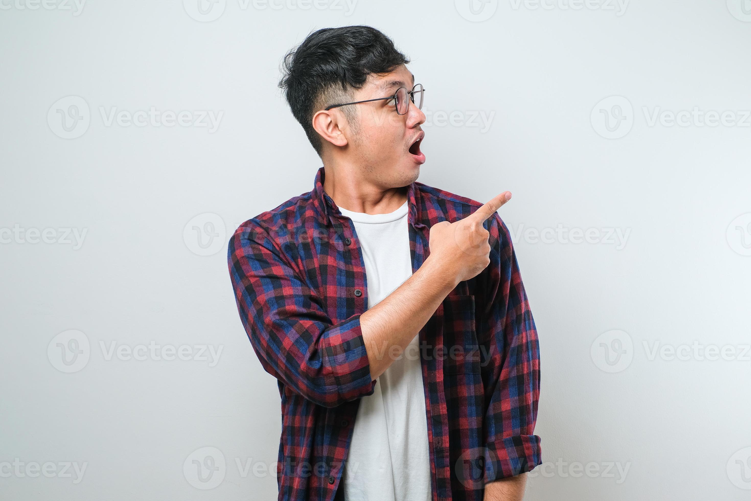 Young handsome asian man pointing with hand finger to the side looking ...