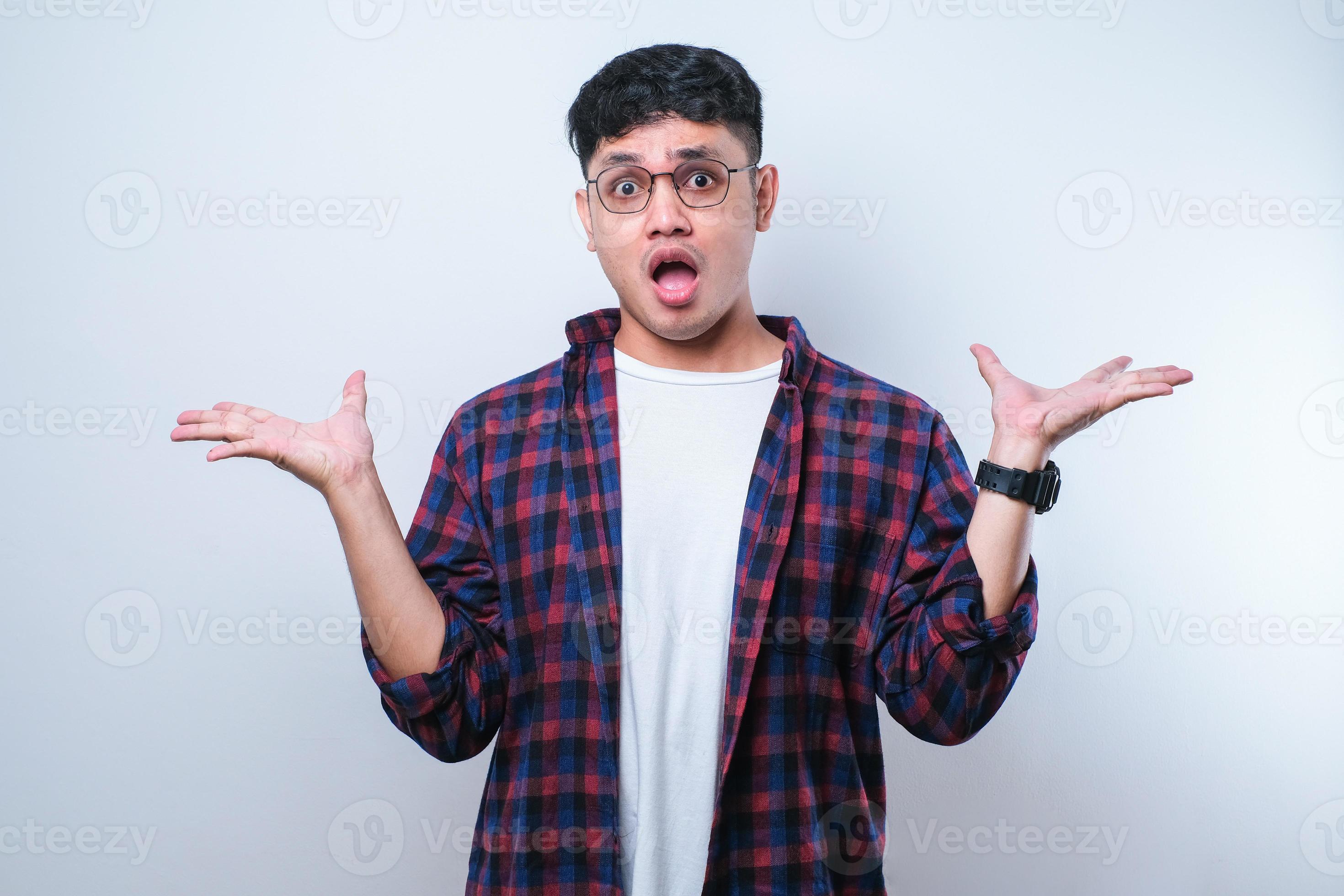 Young handsome asian man clueless and confused expression with arms and ...