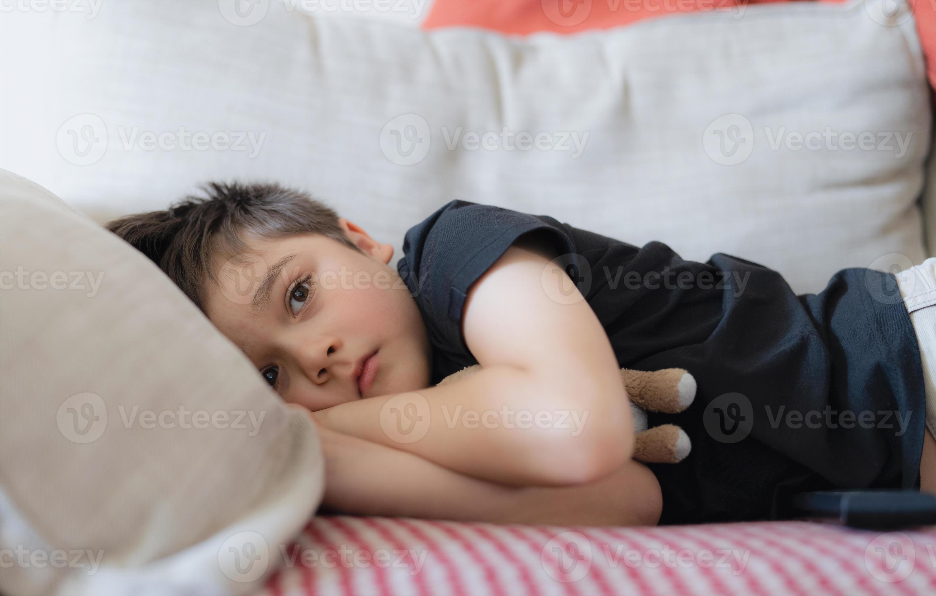retrato dramático niño solitario cara triste acostado en el sofá, niño emotivo acostado en el ...