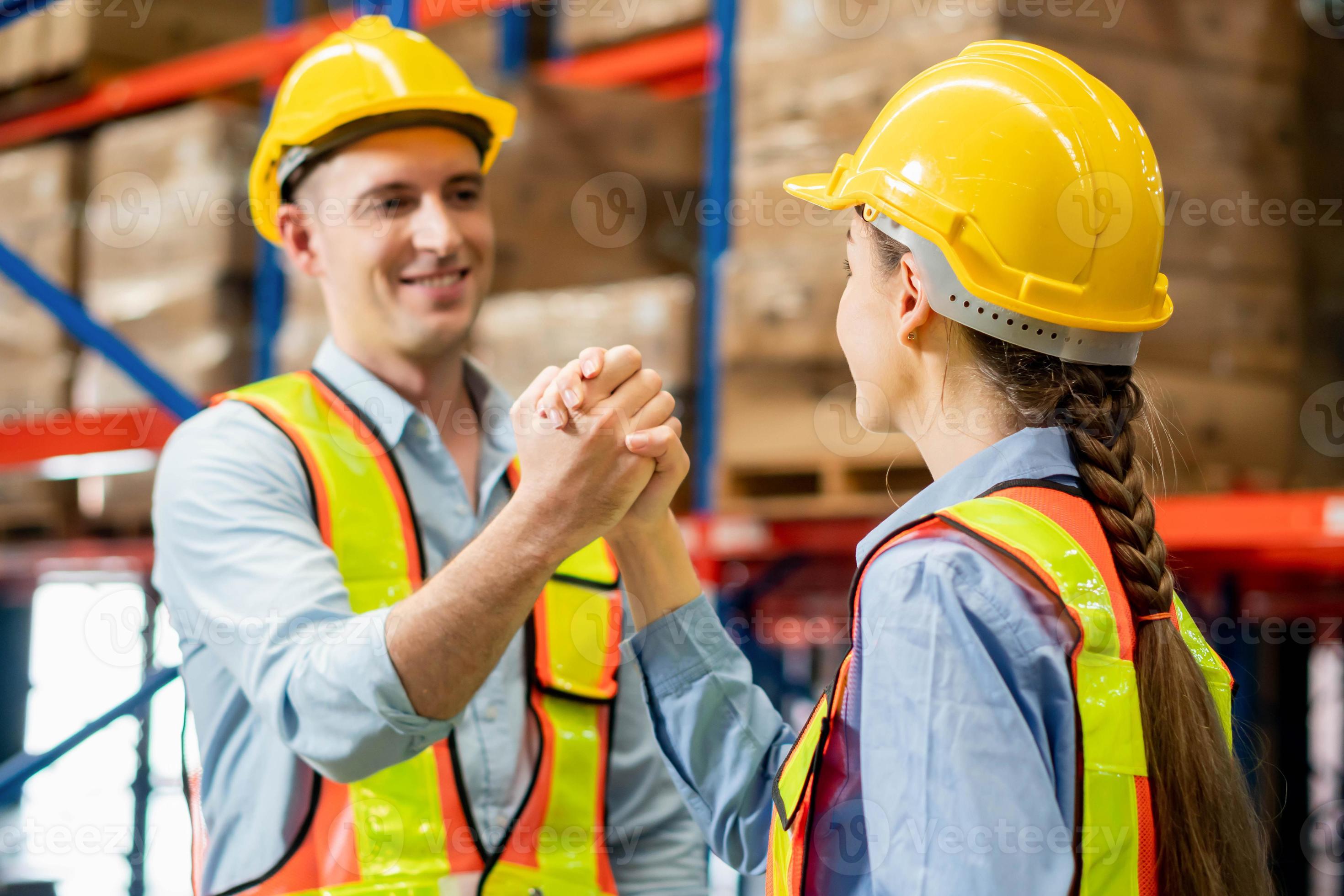 Warehouse workers soul brother handshake, thumb clasp handshake or homie handshake with blurred ...