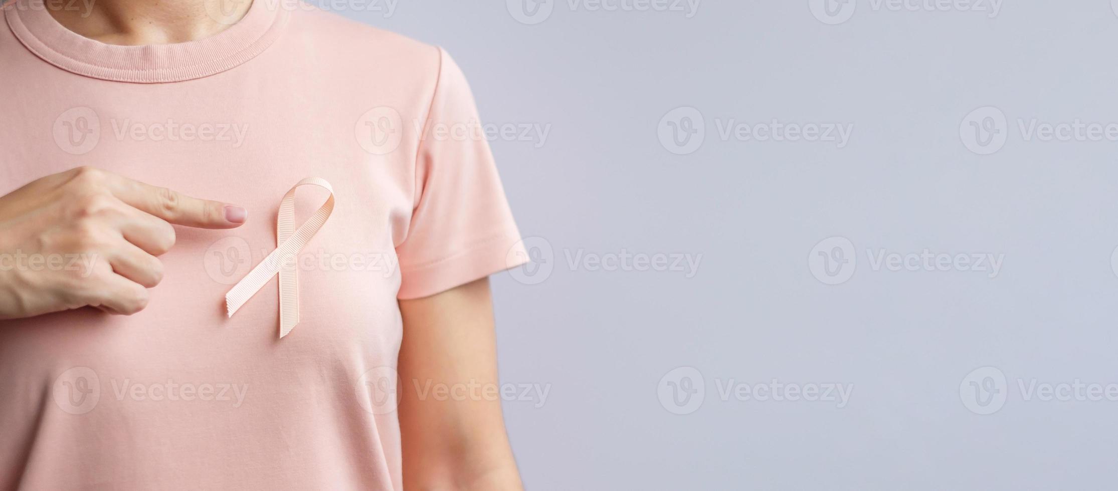 Woman Hand Holding Peach Ribbon For September Uterine Cancer Awareness