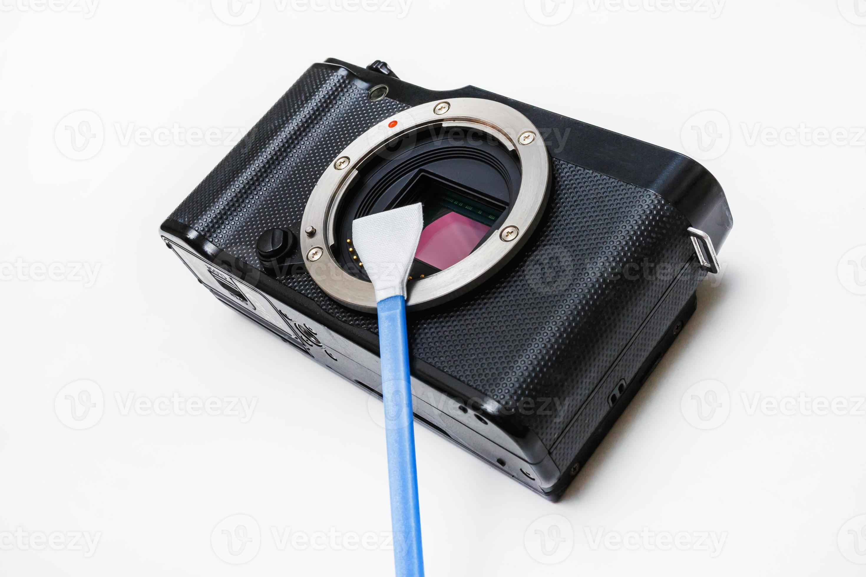 Close-up of mirrorless digital APS-C dirty camera matrix sensor cleaning and maintenance with ...
