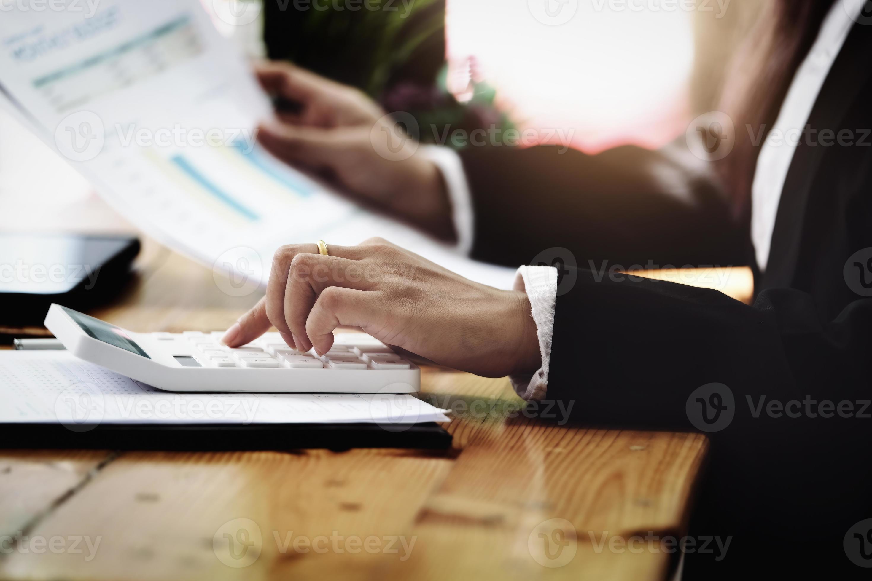 Business woman using calculator to review balance sheet annual using ...