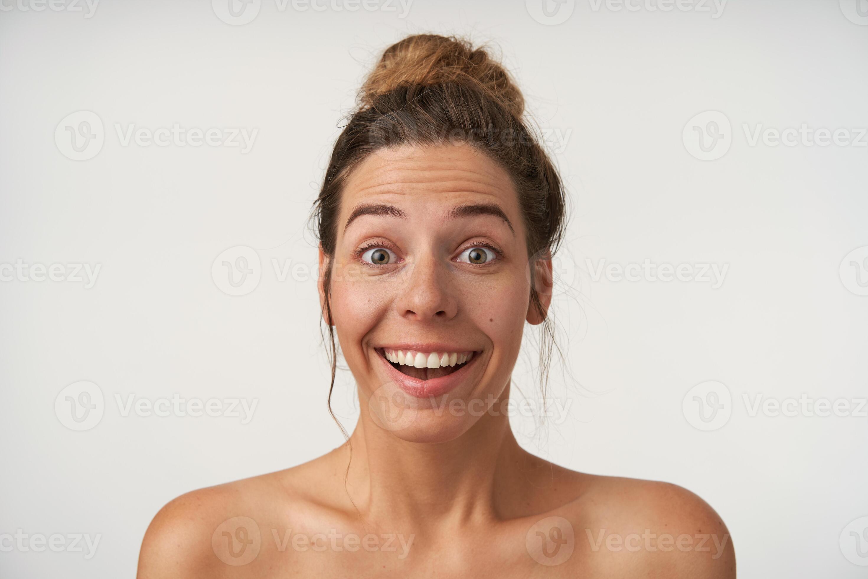 Indoor close-up of surprised young pretty woman with casual hairstyle ...